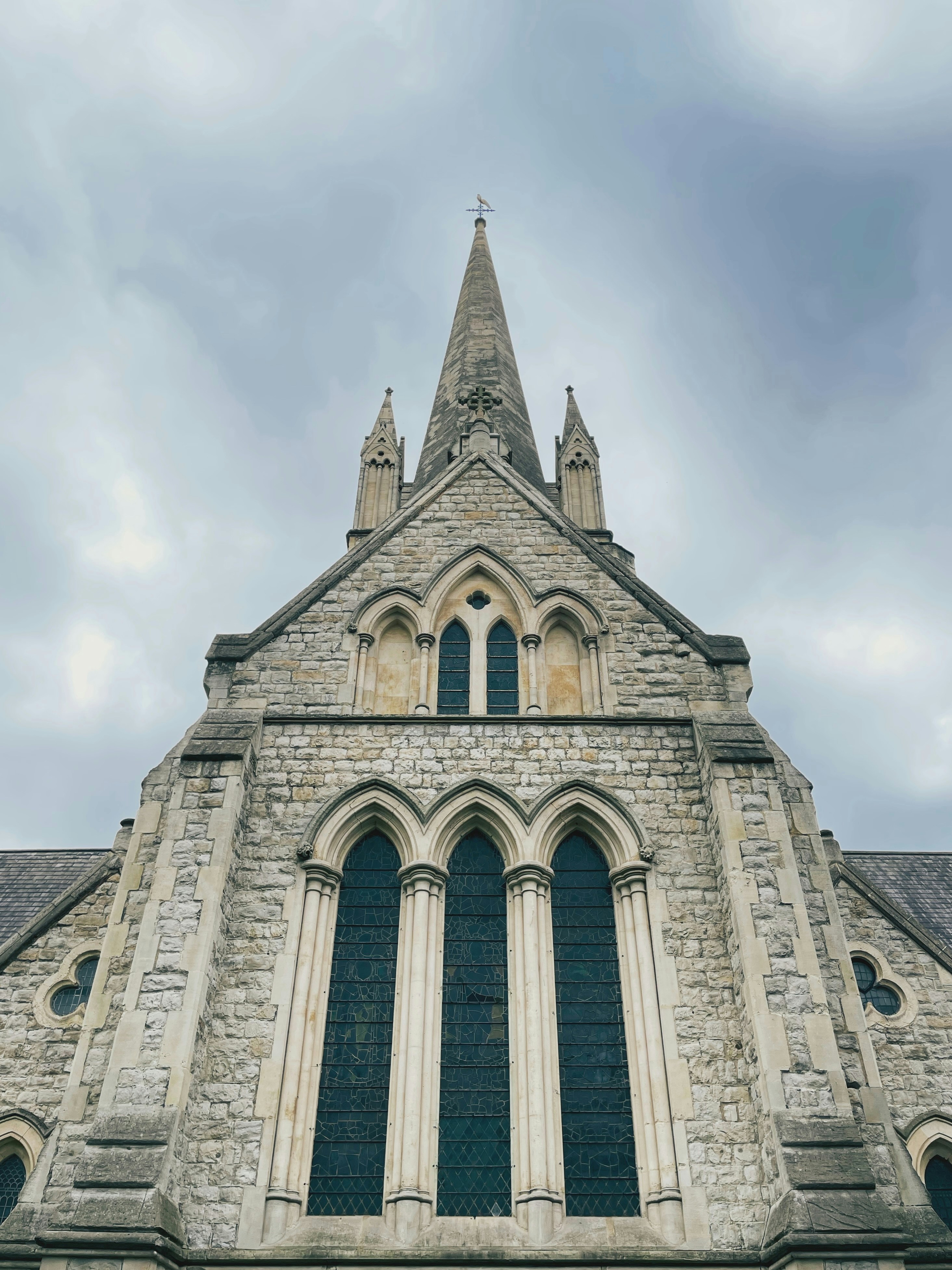 Stone church spire against a cloudy sky