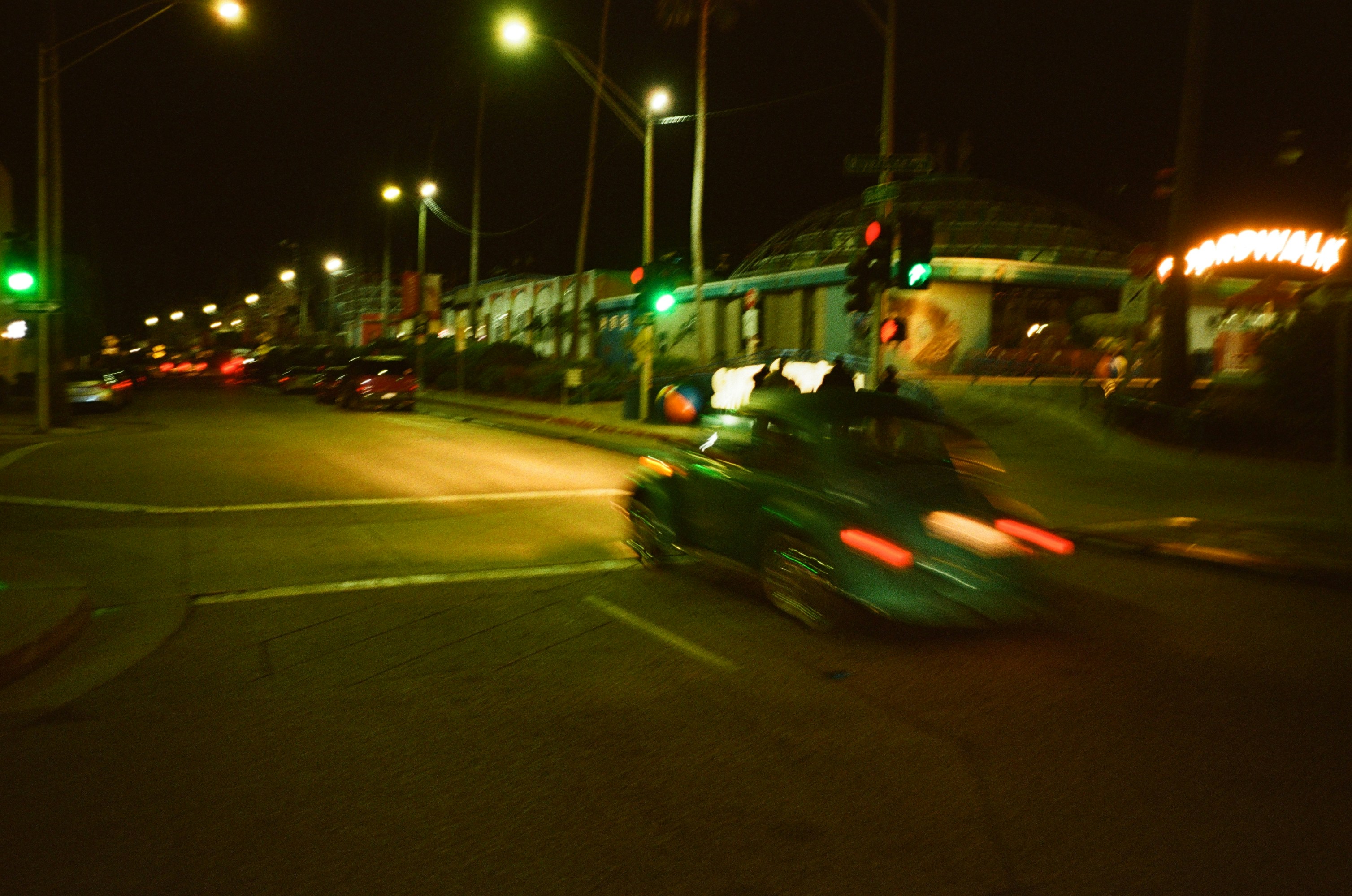 Car driving at night on city street