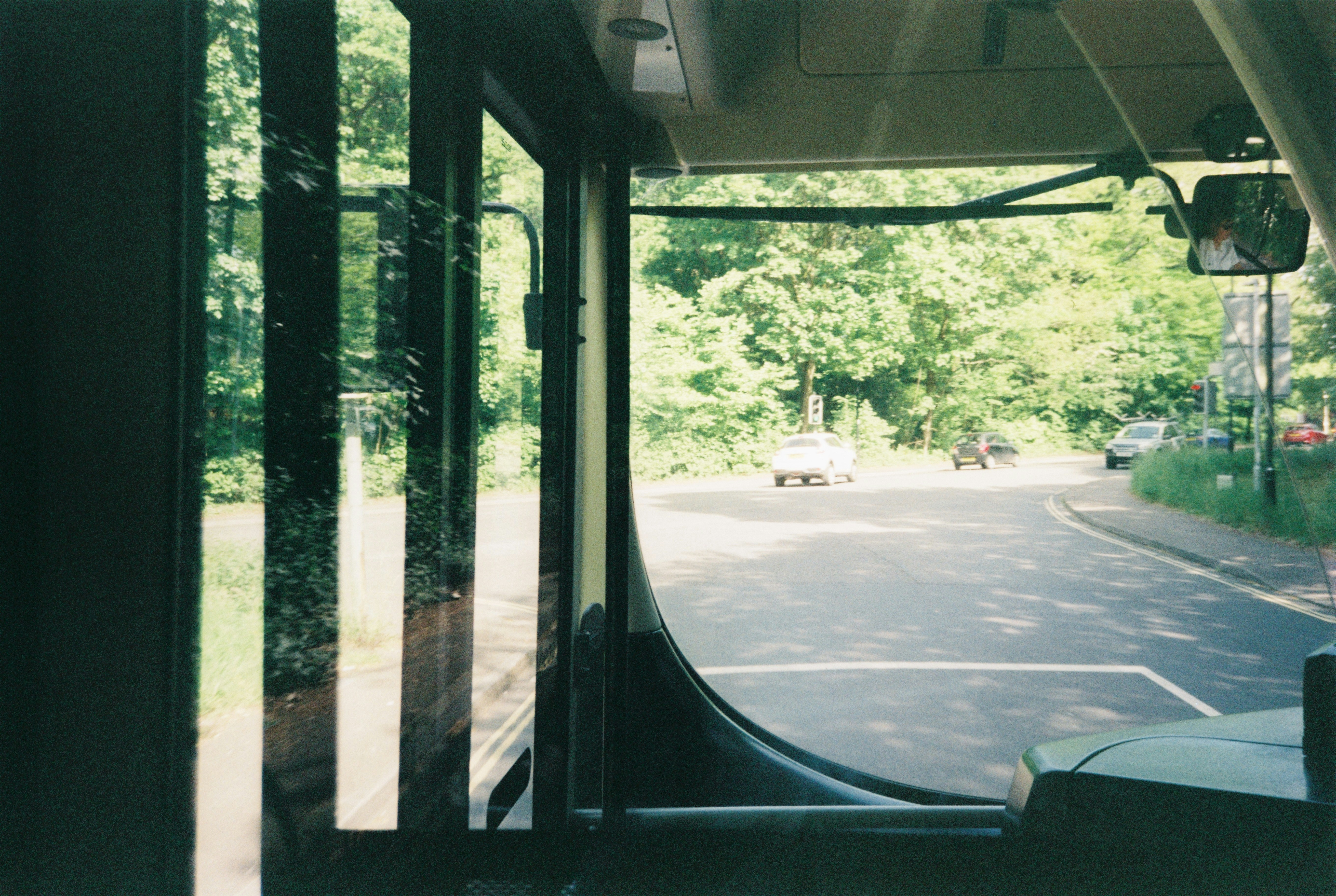 View from a bus window of a road and trees