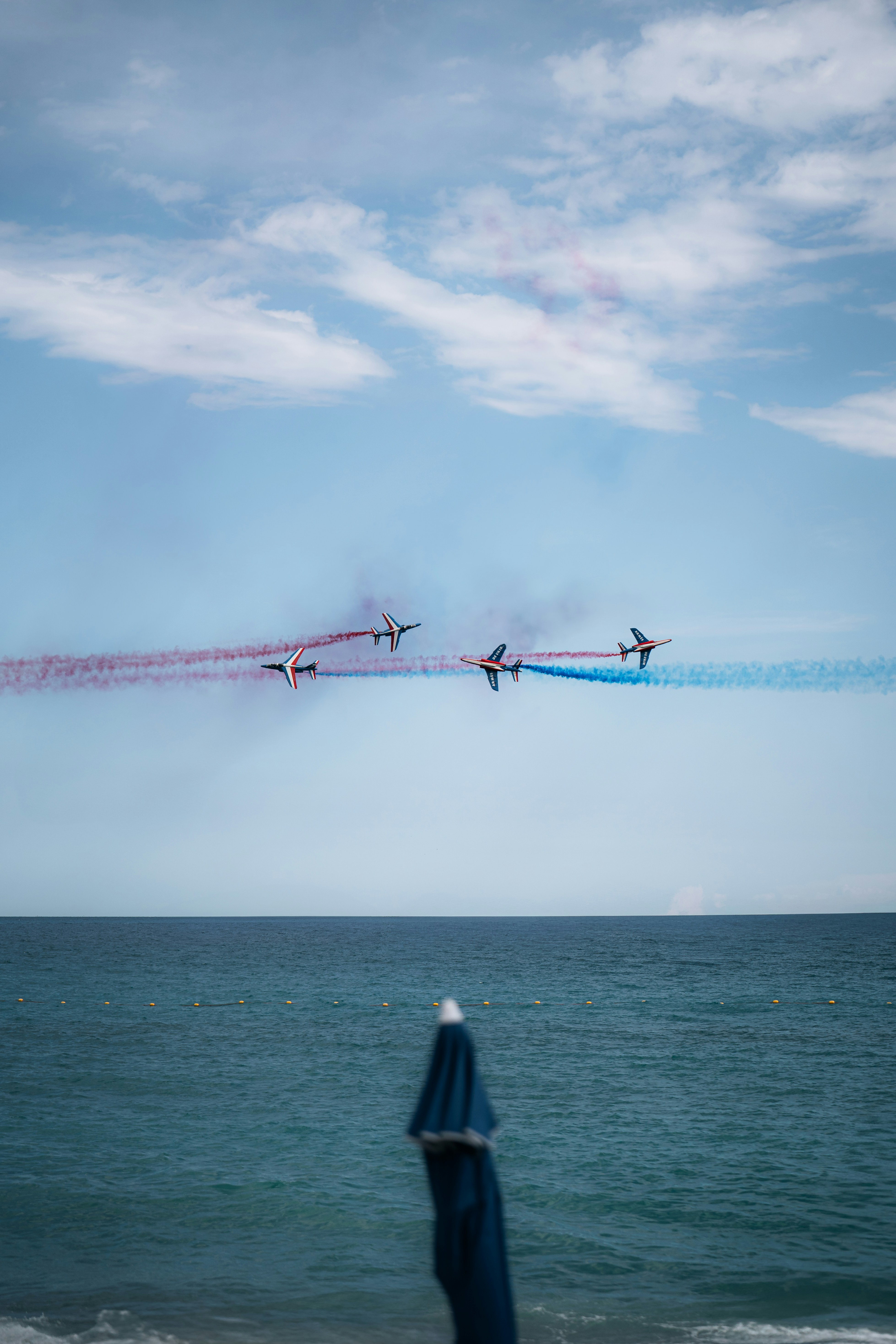 Chromatic Contrails Over the Seafront: Four-Jet Precision Above Calm Waters