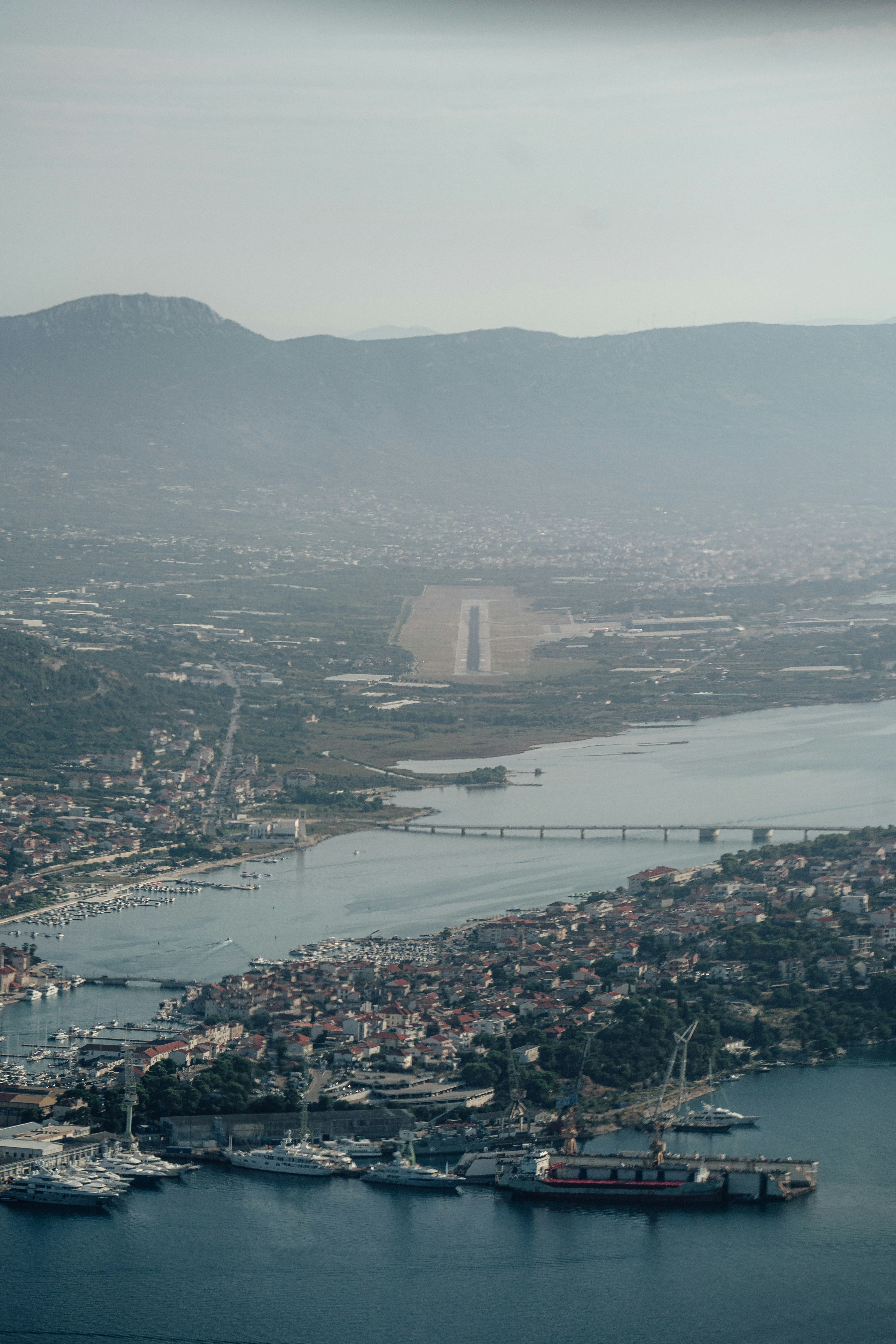 Aerial view of a coastal city with an airport runway.