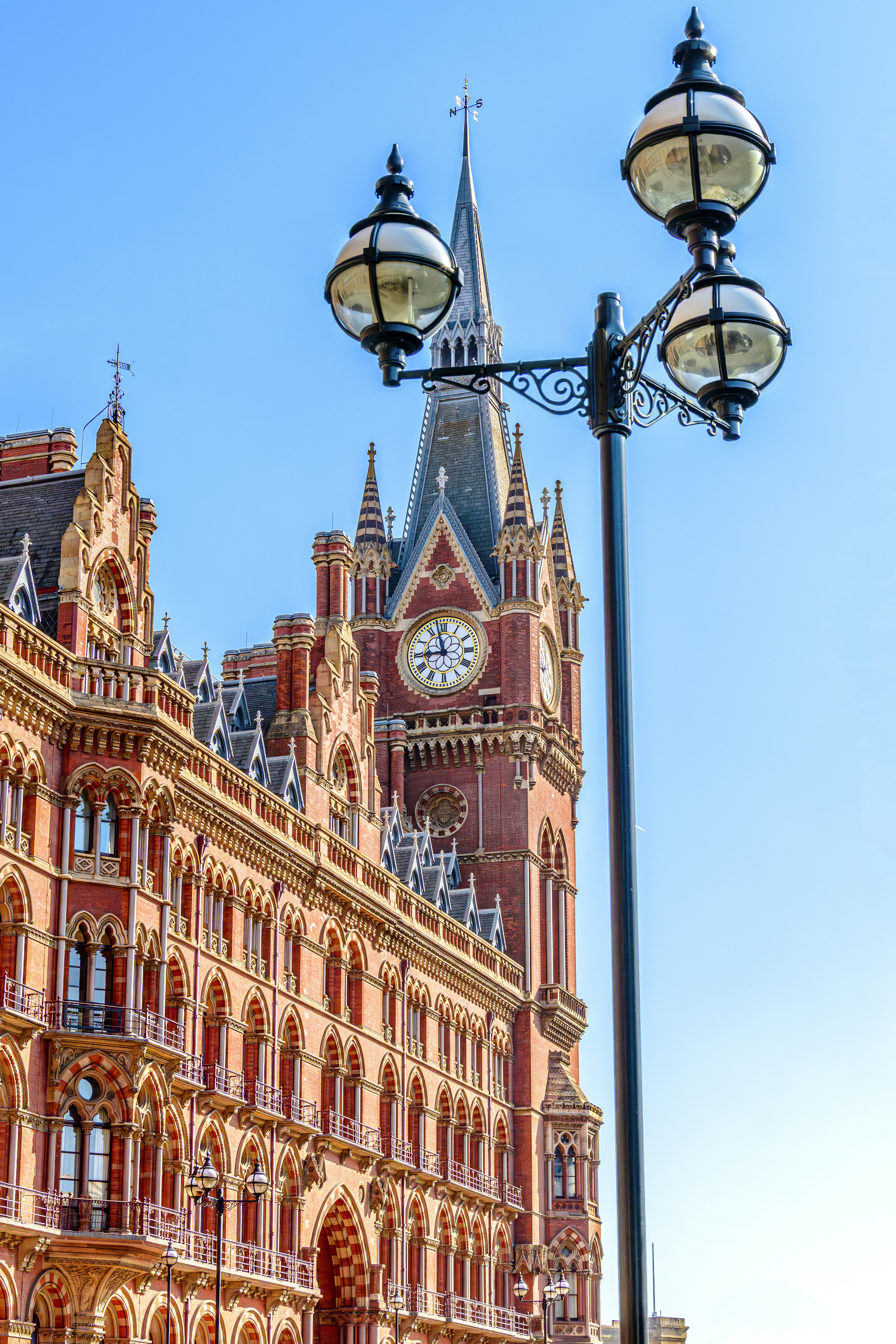 Victorian architecture with a clock tower and lamppost