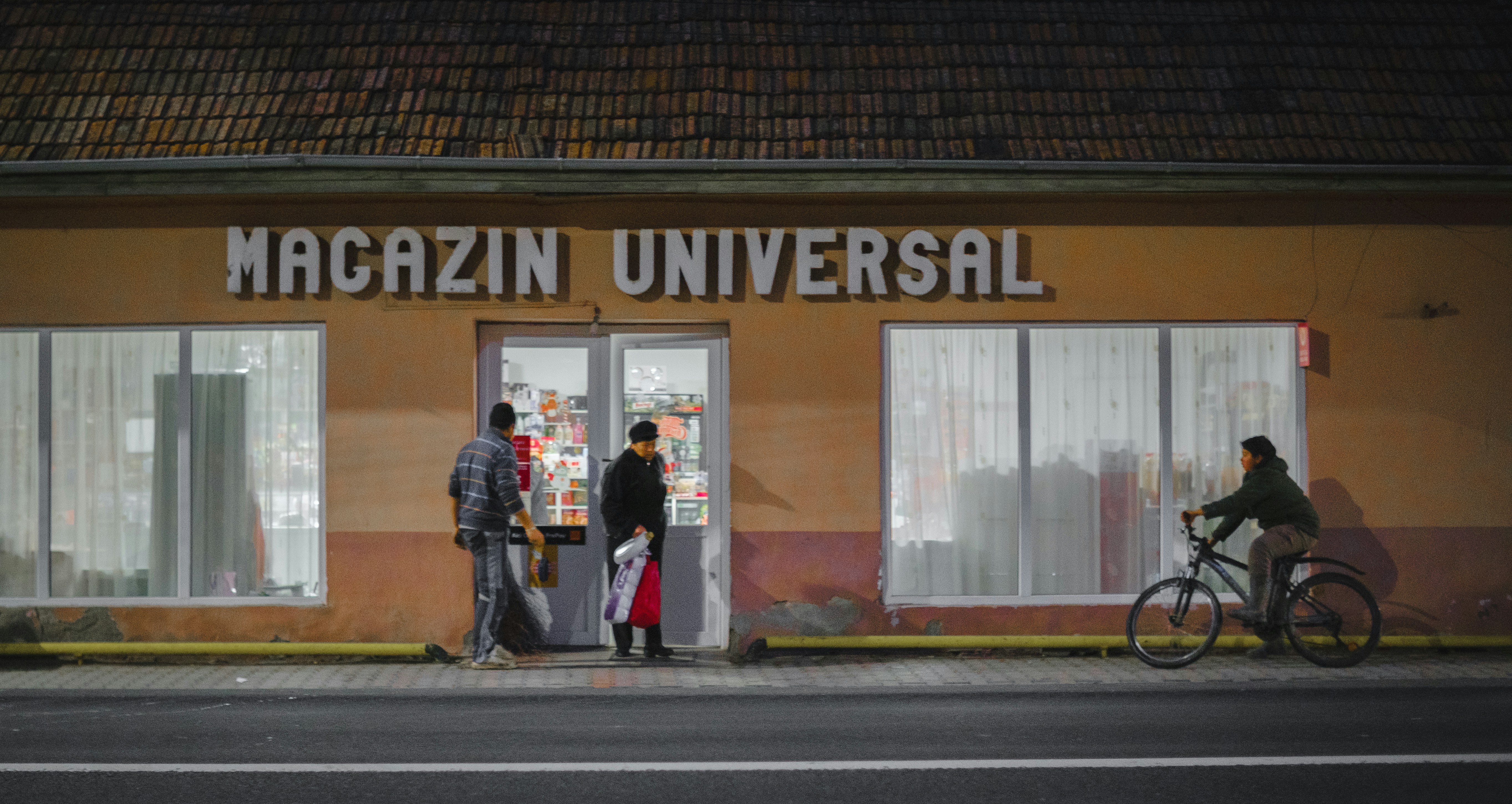 People enter a universal store at night