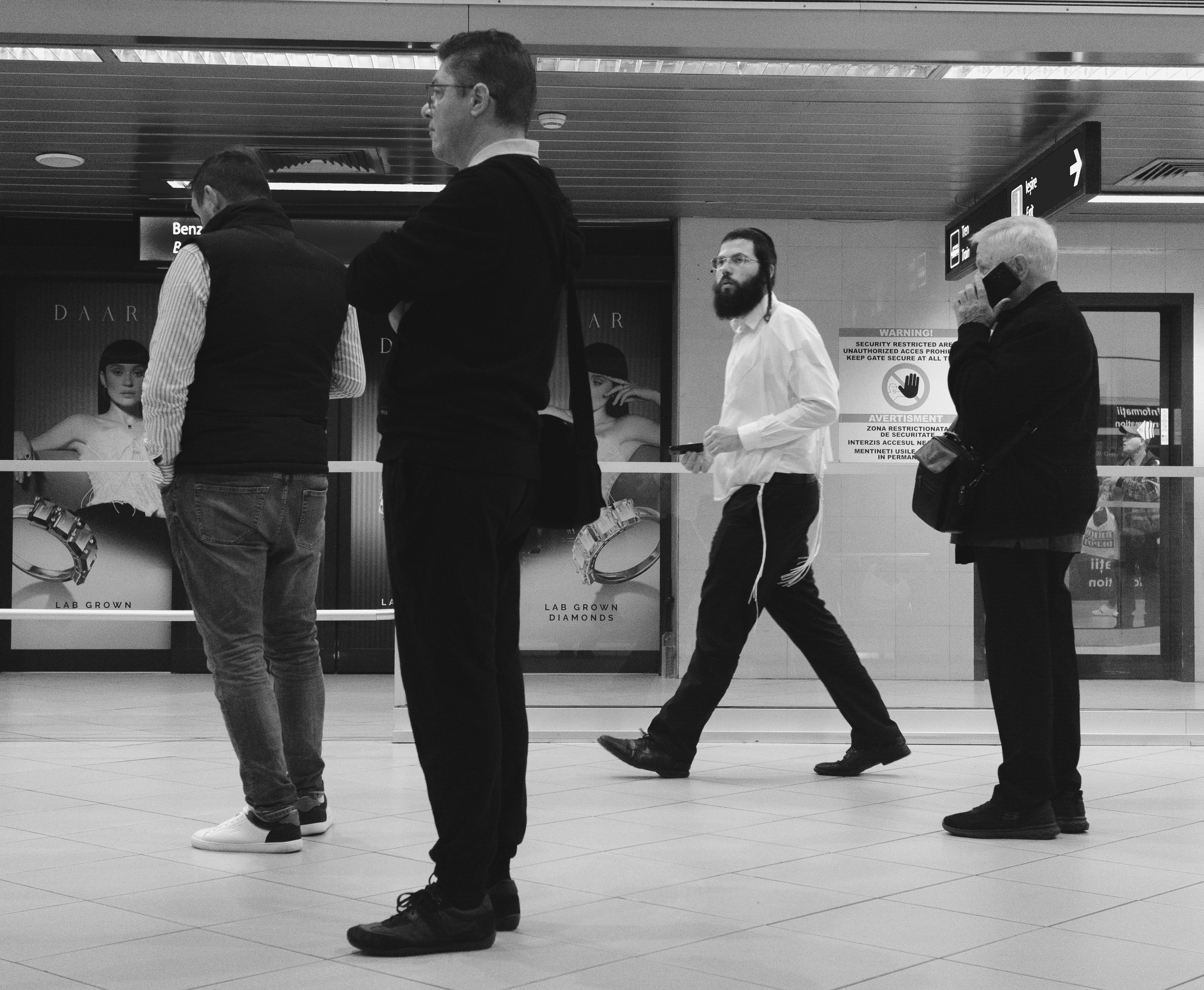 People waiting and walking inside a modern building.