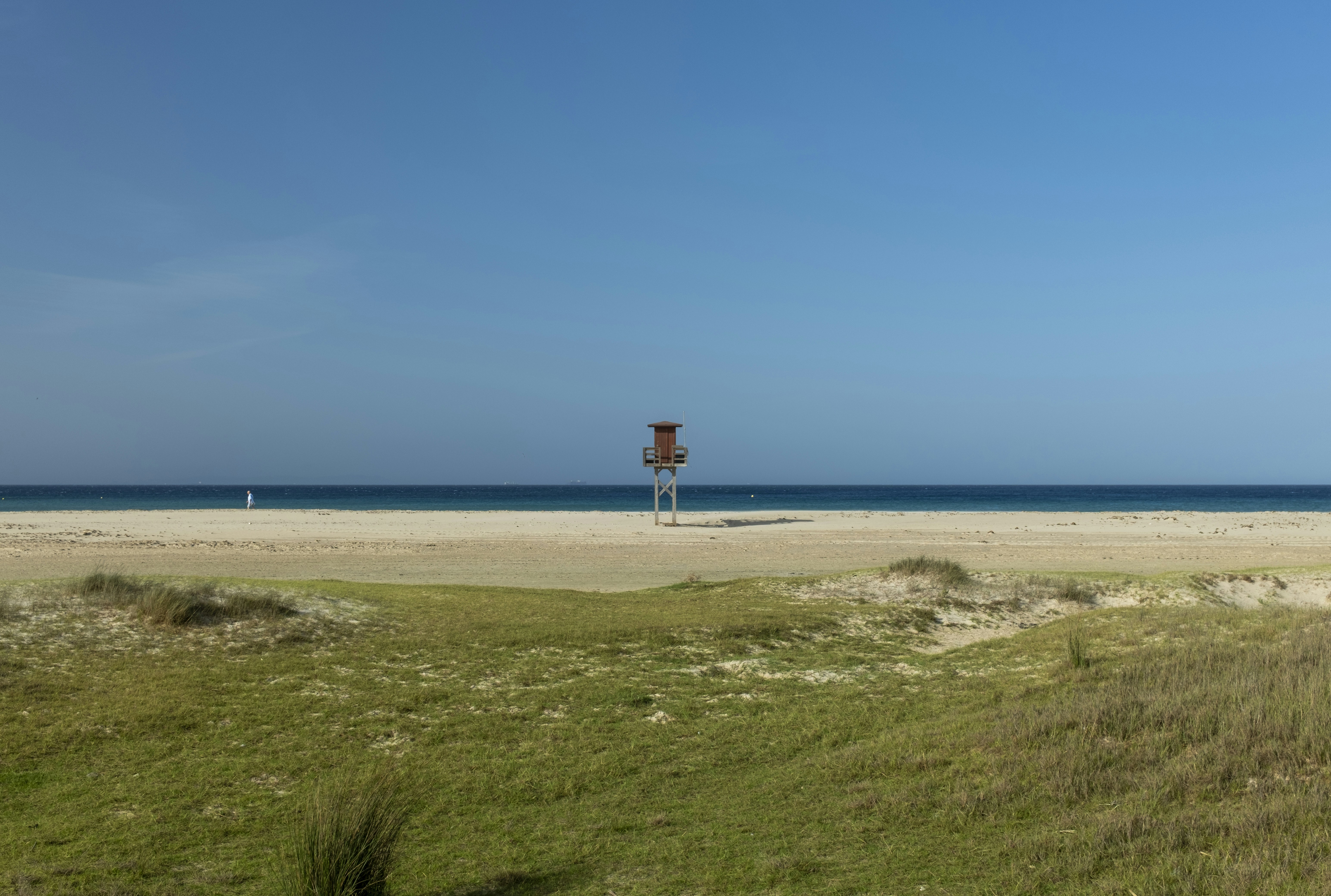 Lifeguard tower on a sandy beach with ocean background