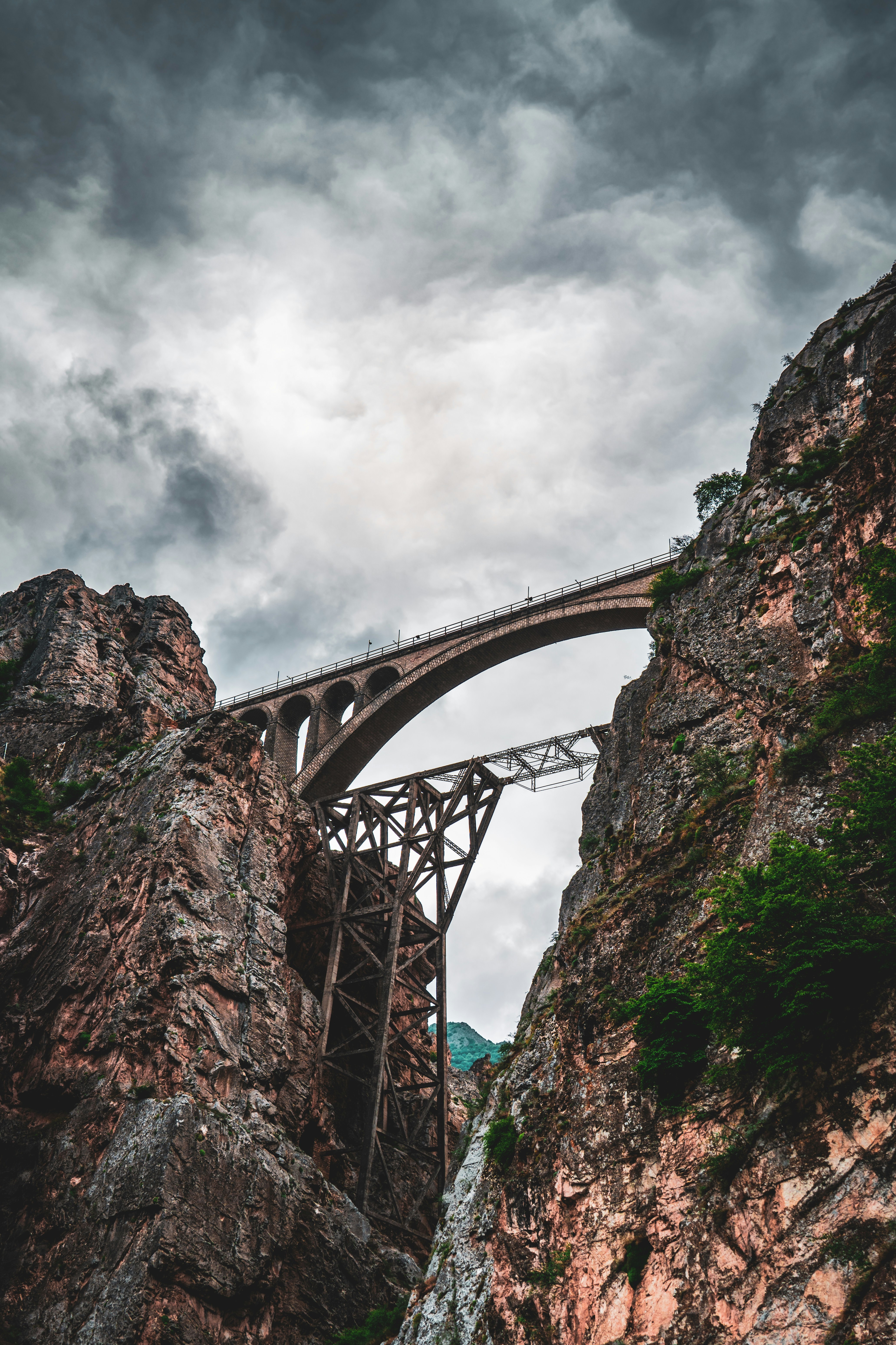 Two bridges span a rocky canyon under cloudy skies photo – Free ...