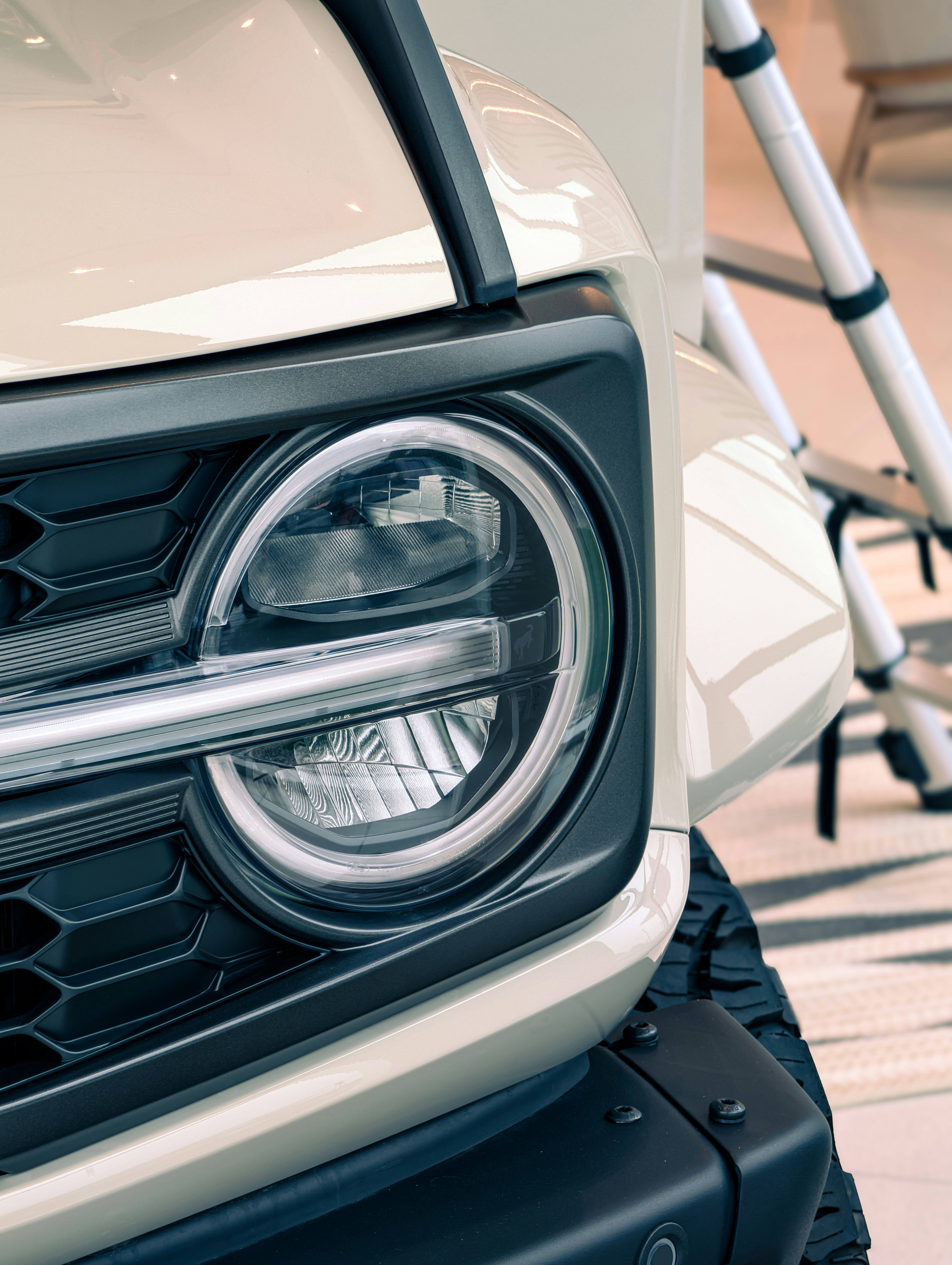 Detailed view of a vehicle's headlight and grille, showcasing modern automotive design elements. The sleek lines and textures highlight craftsmanship.