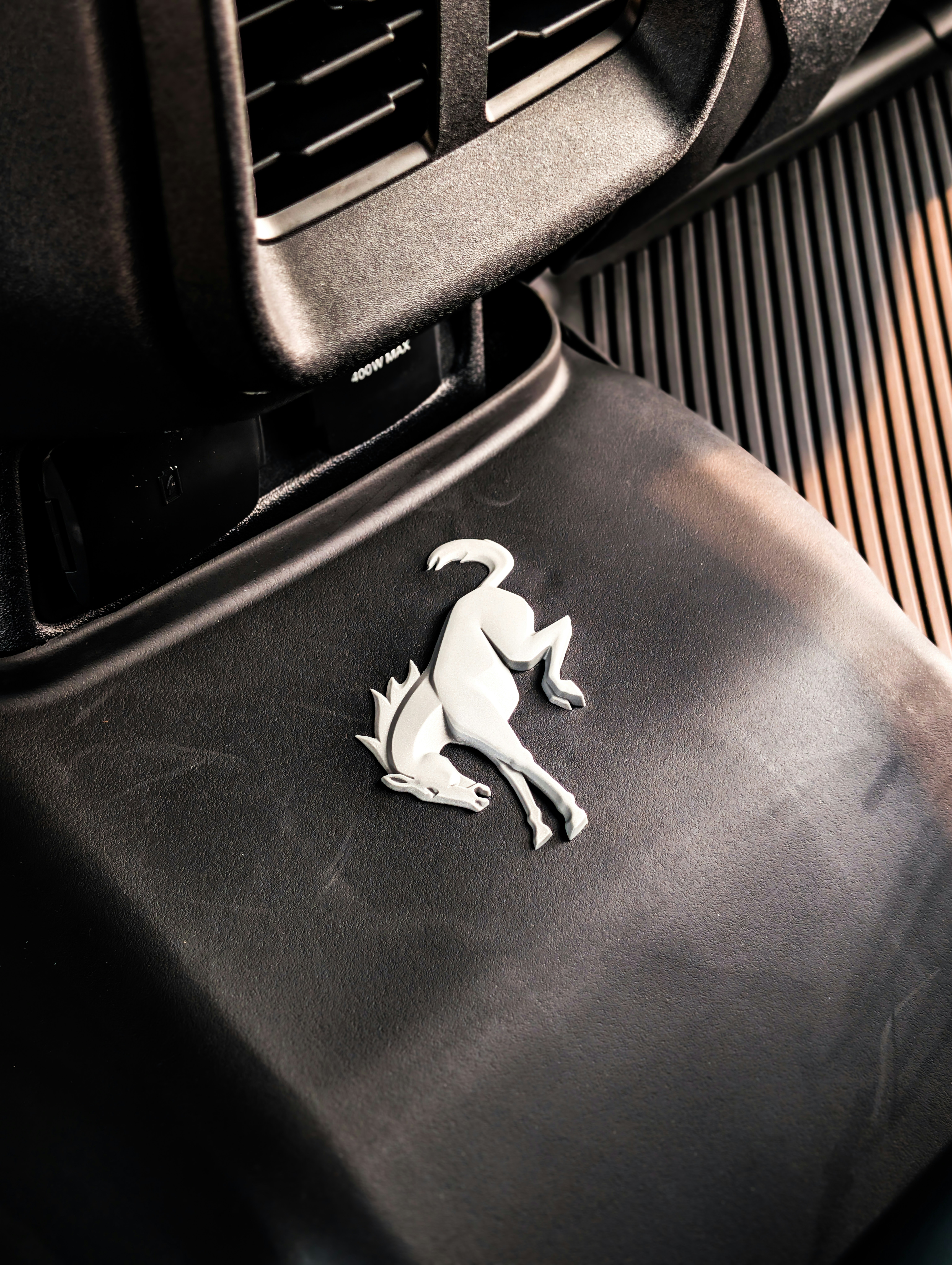 Stylized horse emblem on a sleek automotive interior, showcasing luxury and performance. The design reflects the brand's heritage and commitment to excellence.