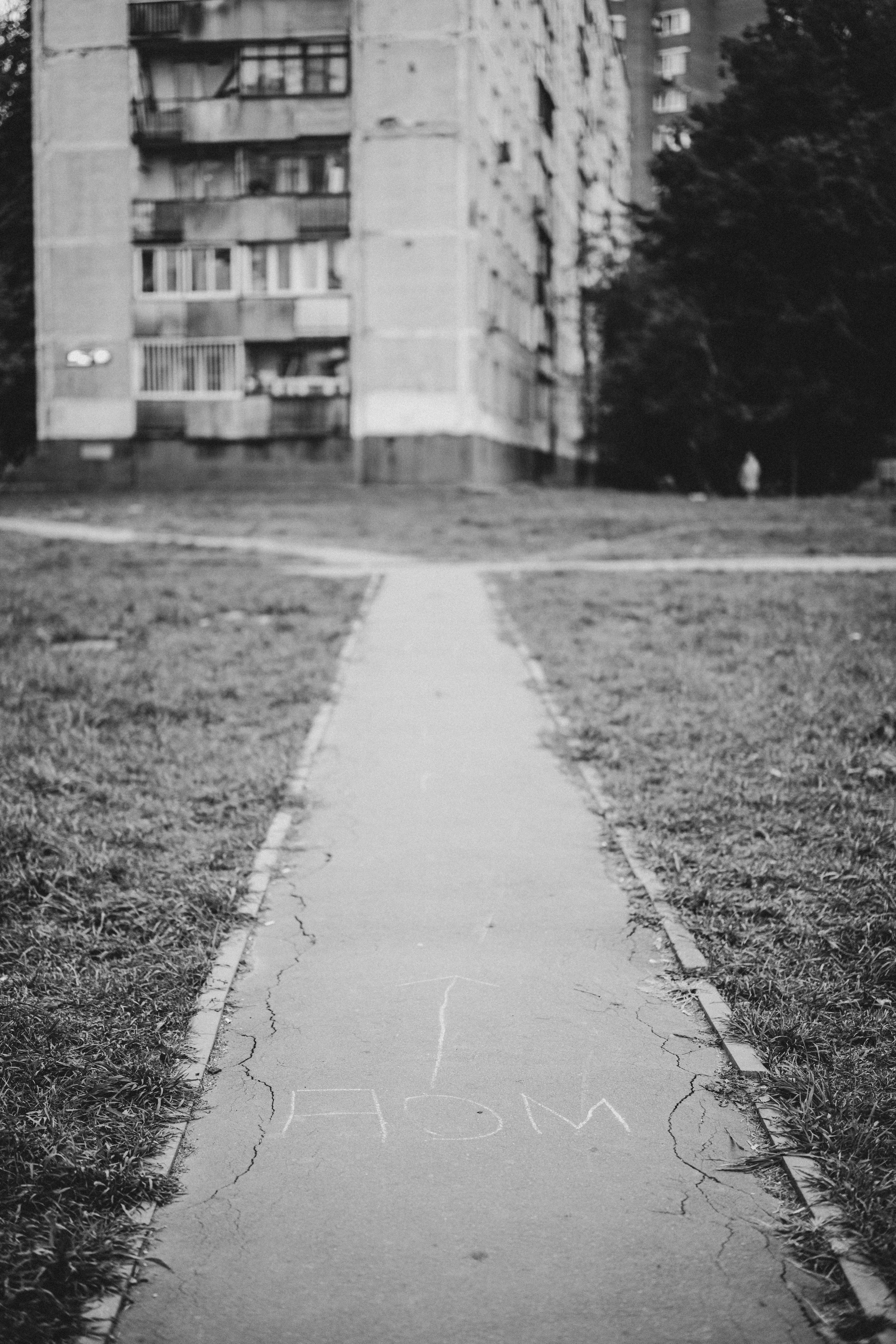 Home → | A concrete path leads to apartment buildings.