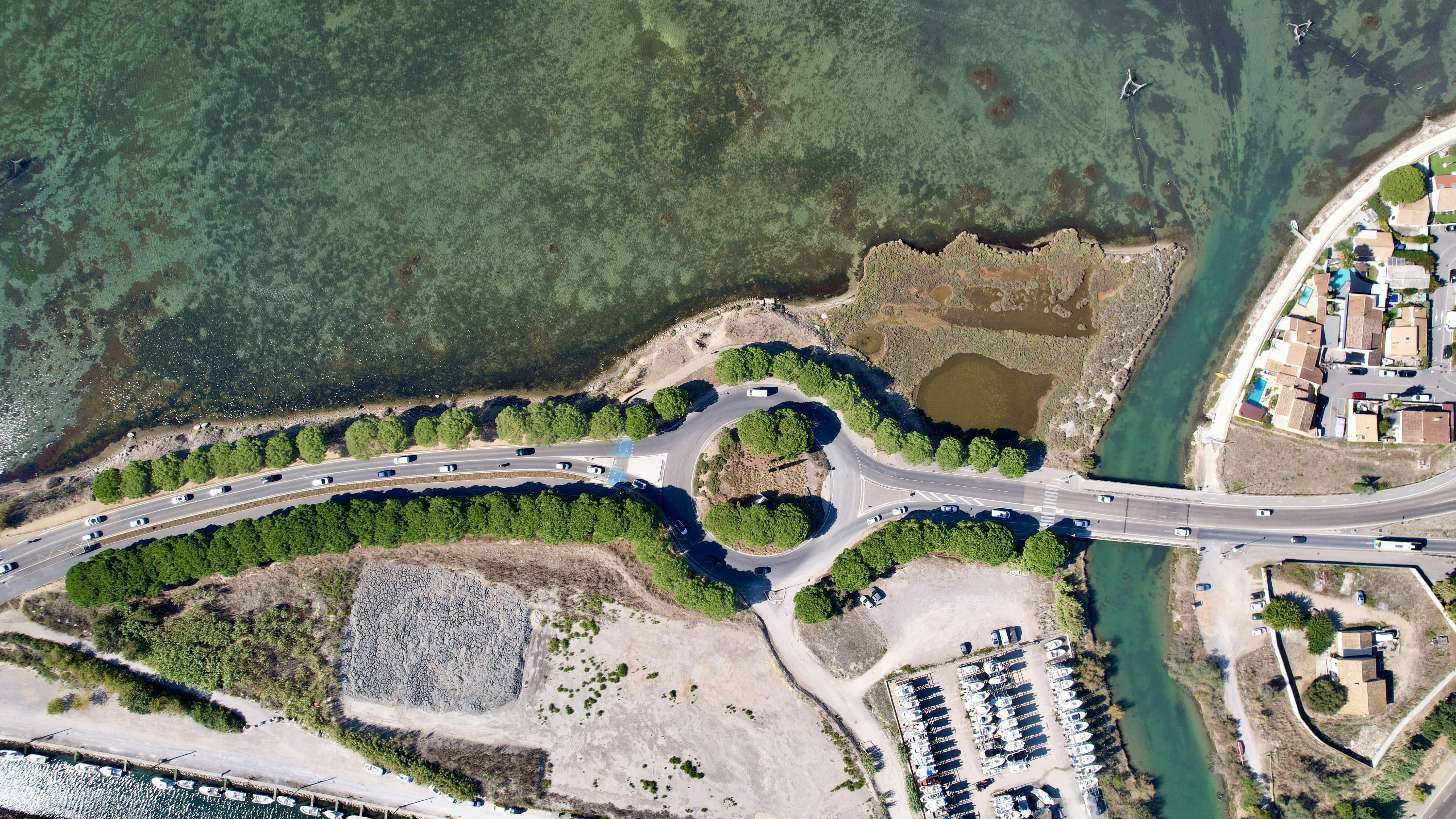 Beautiful Roundabout with water around it | Aerial view of coastal road with roundabout and canal.