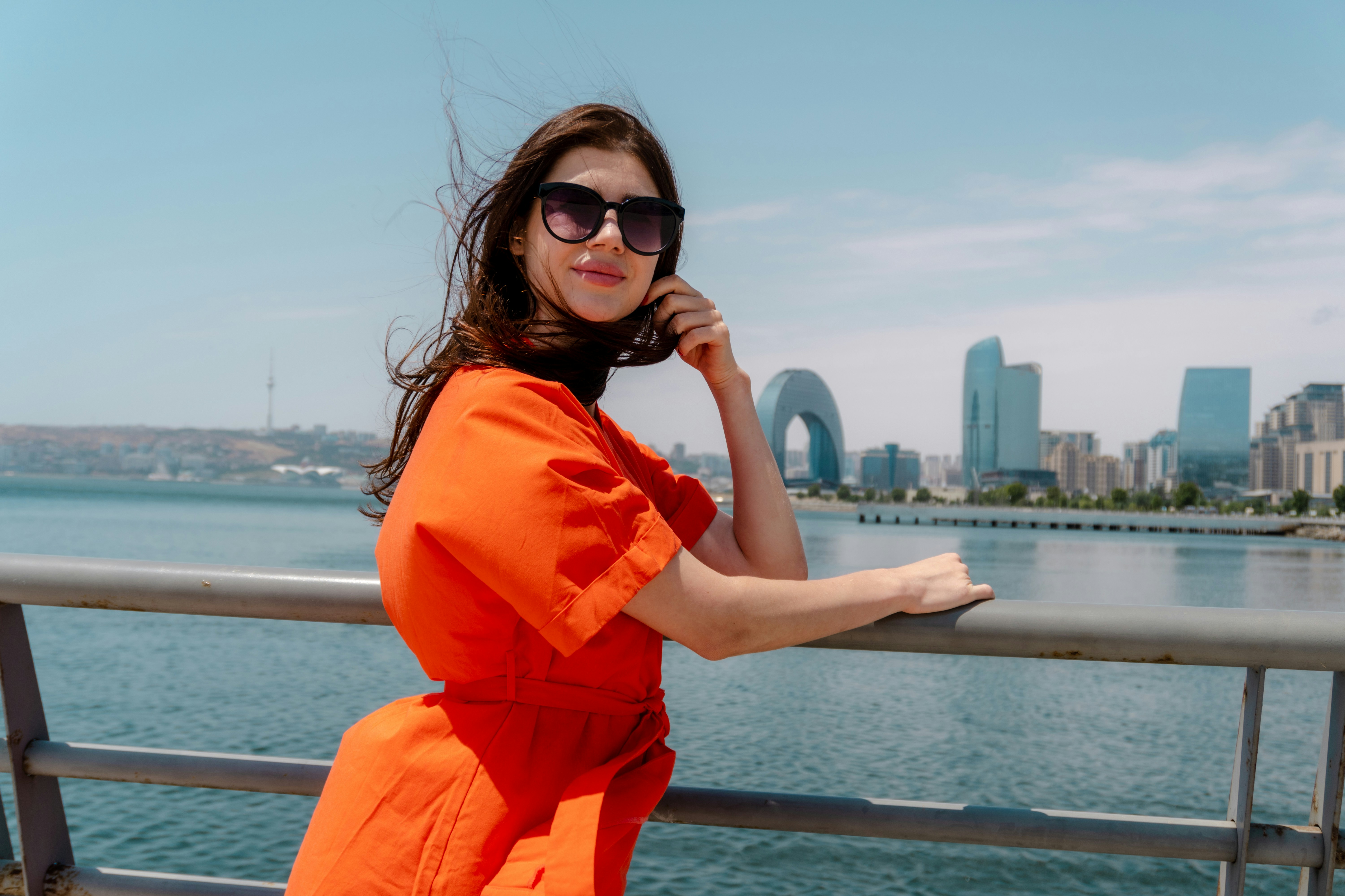 Woman in orange dress with city skyline background