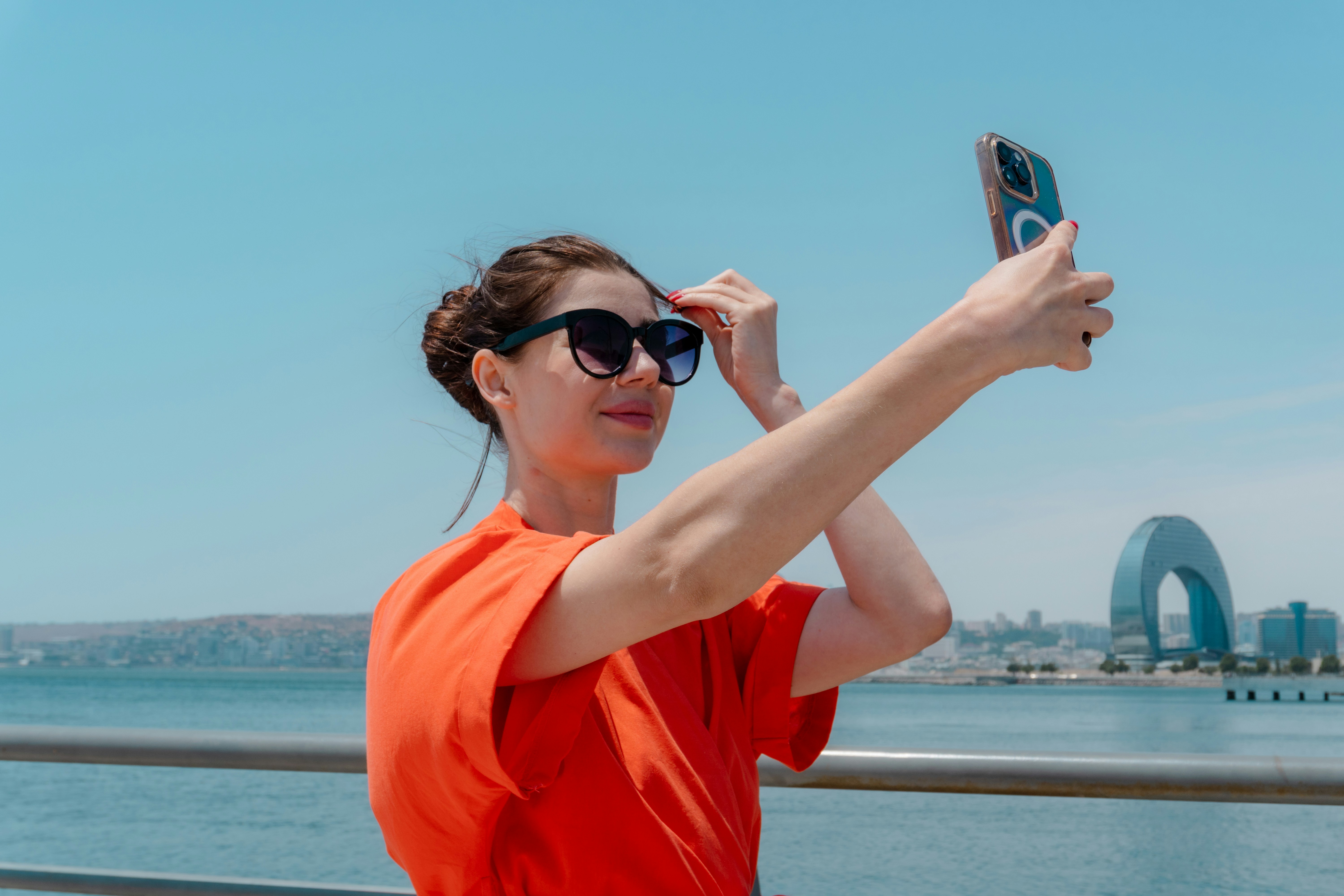Sunlit Selfie by the Seafront Arc: Orange Pop at the Waterfront