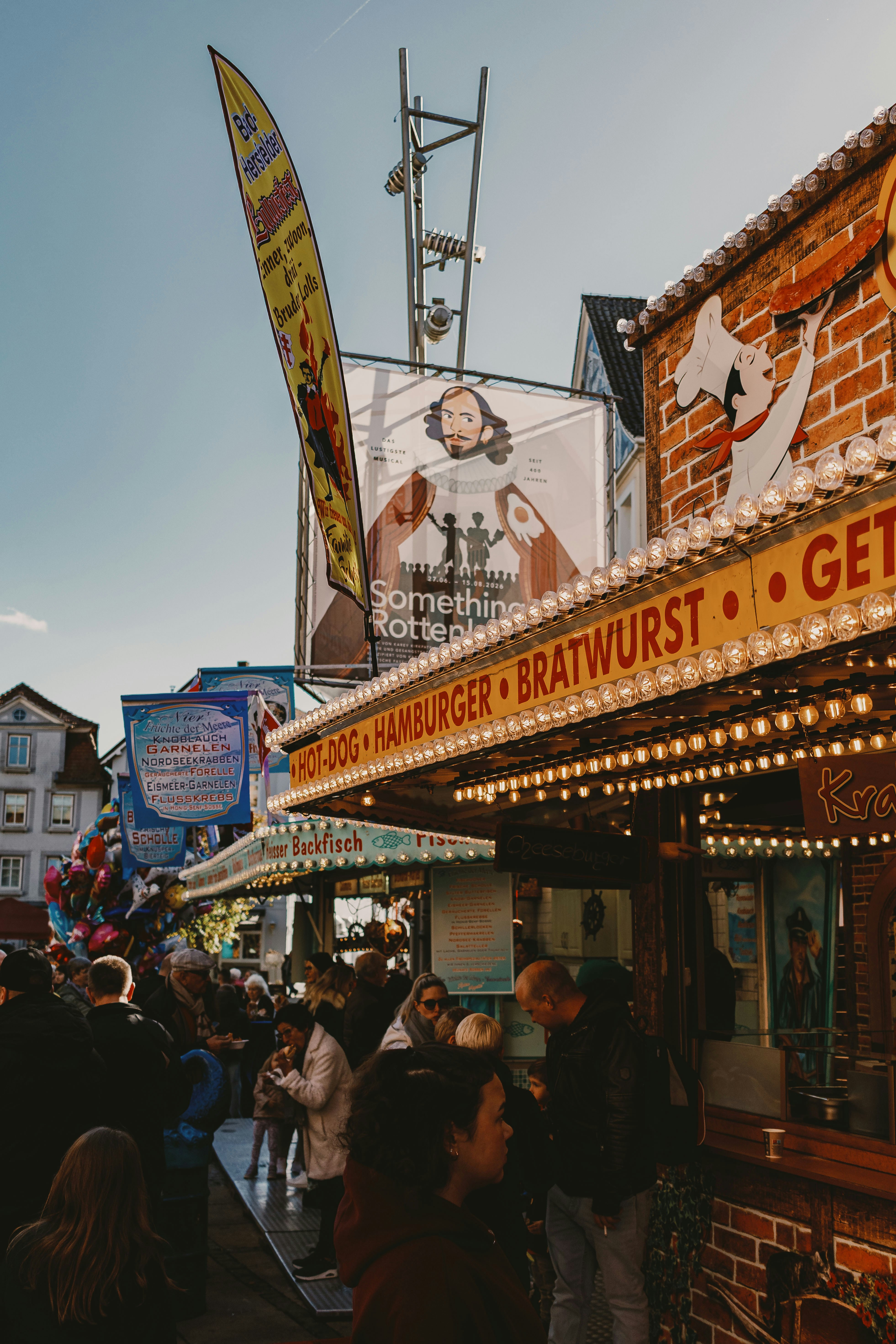 Brick-Warmed Glow: Night Market Standlight with Sausages and Crowd