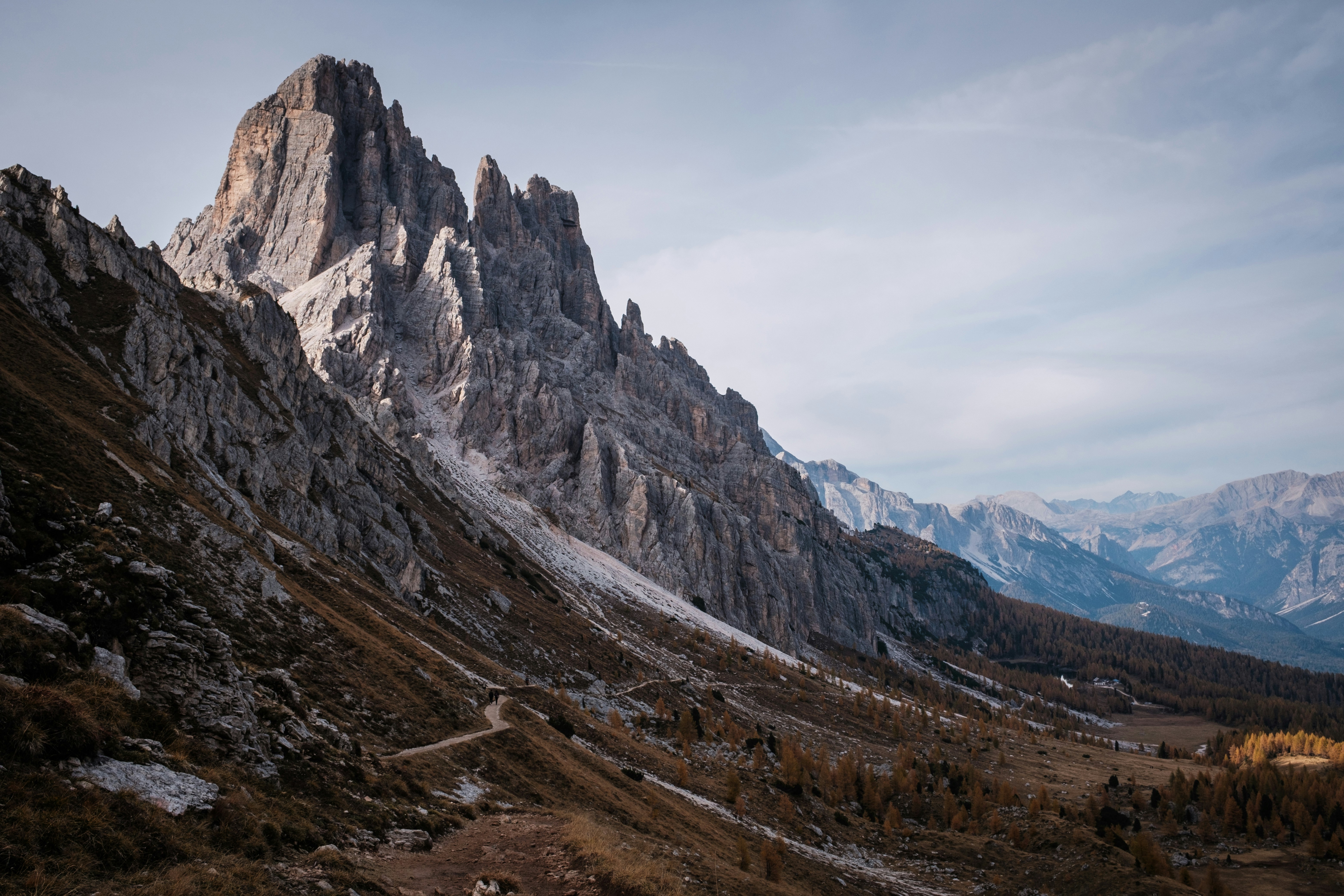 Jagged mountain peaks rise above a dry, grassy valley.