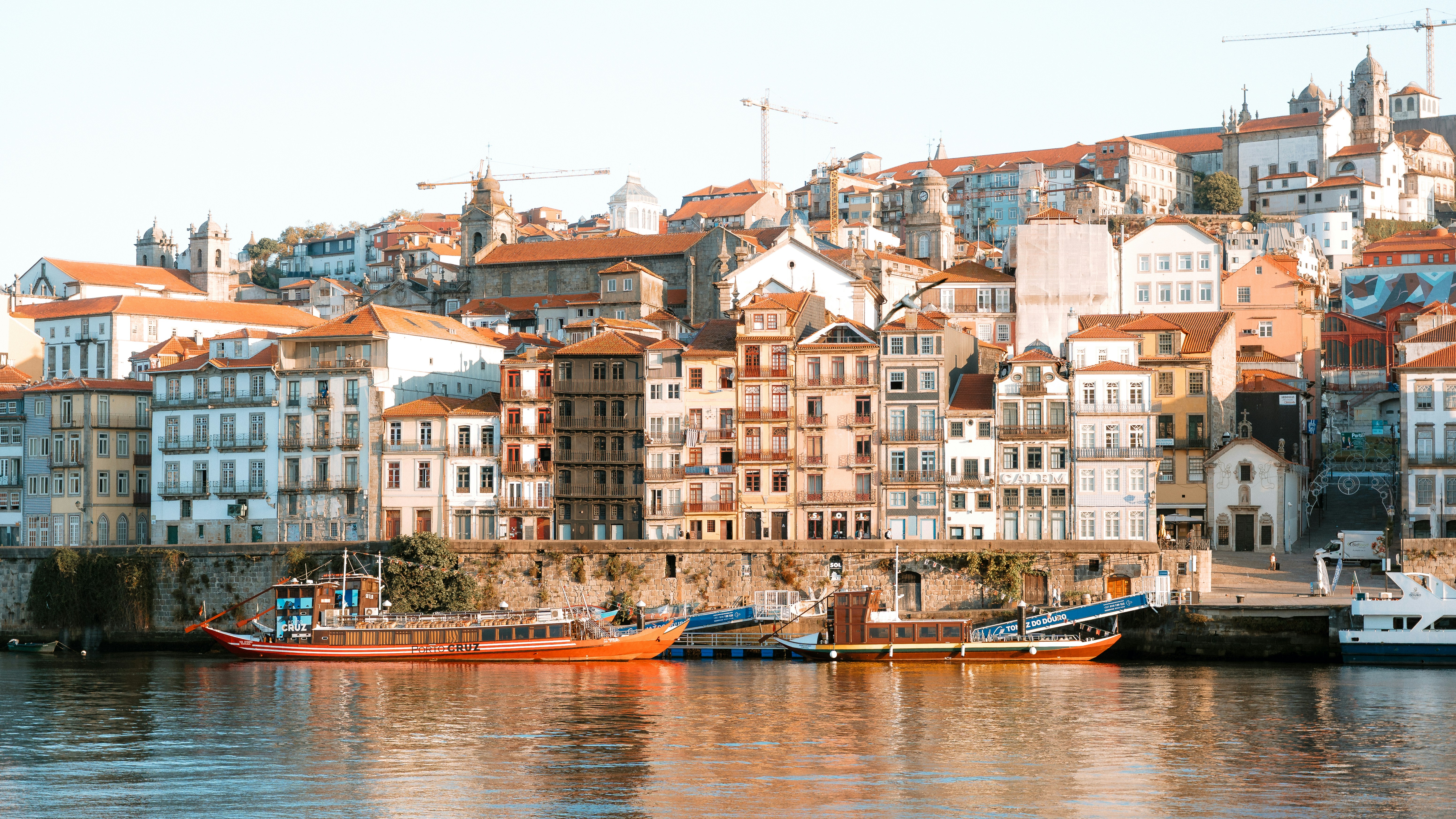 Colorful buildings line a river with boats.