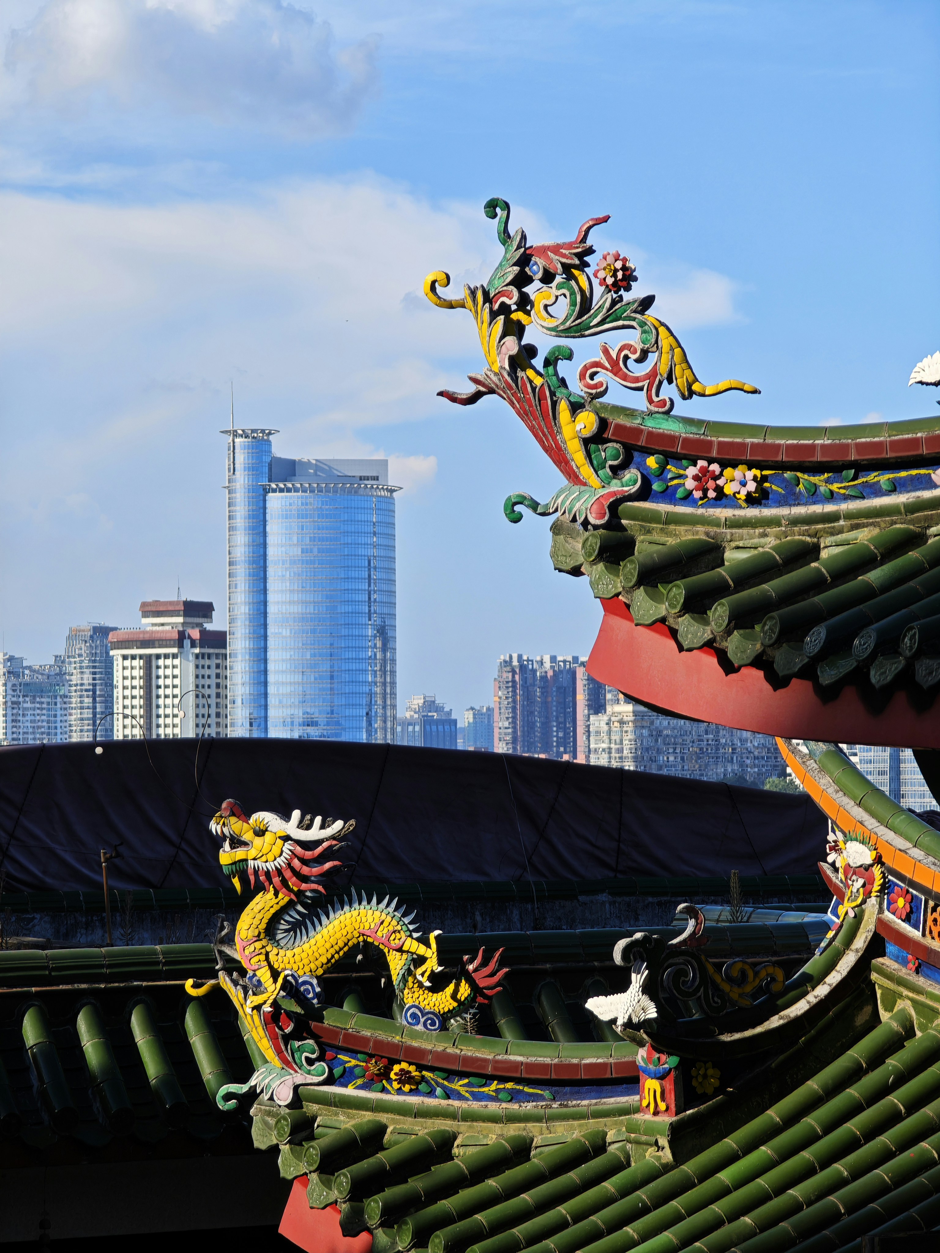 Ancient buildings in front of my eyes, modern ones far away on the opposite side. What a wonderful scene of the old and the new! | Colorful dragon ornaments on traditional temple roof