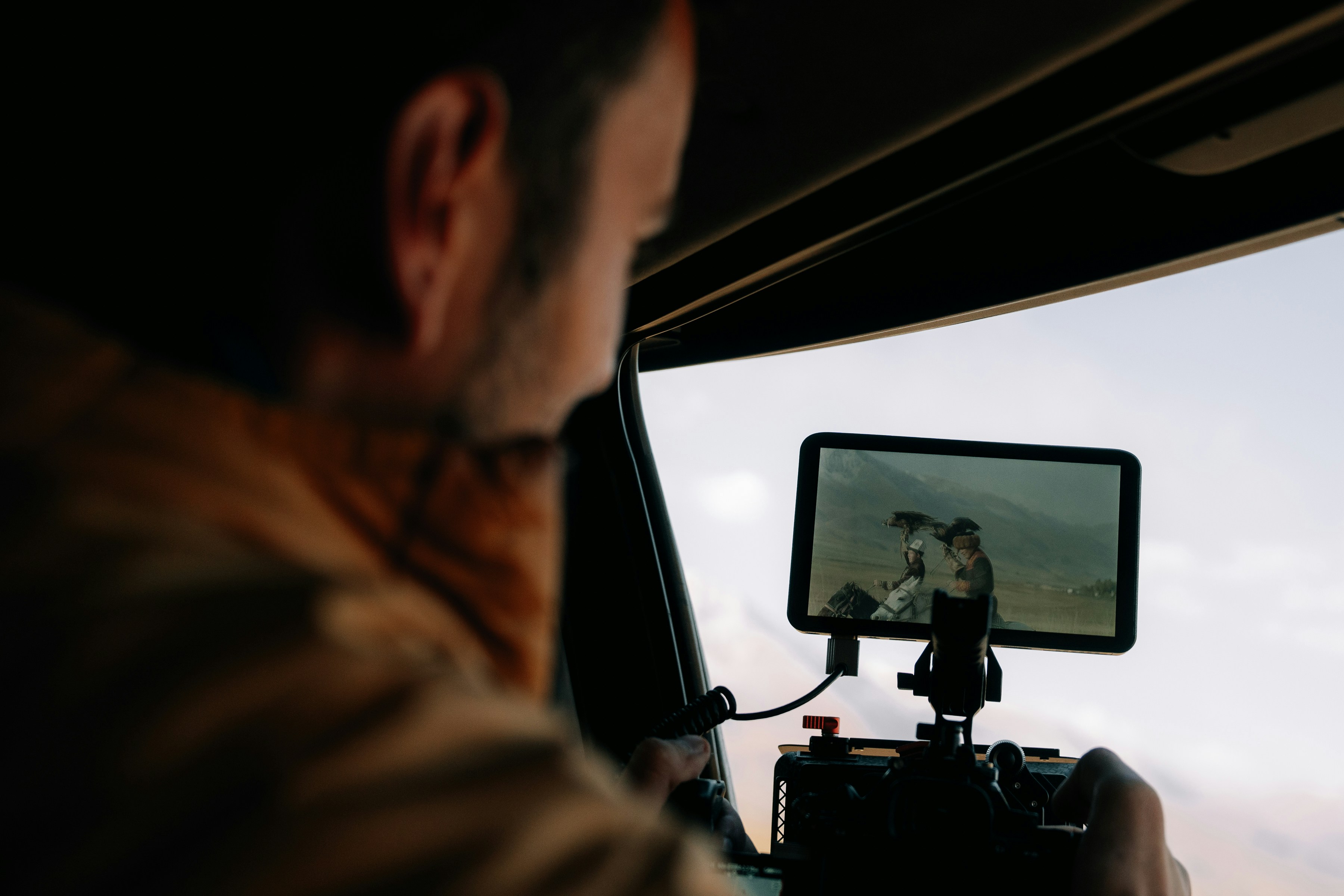 Filmmaker reviews footage on a monitor during flight.