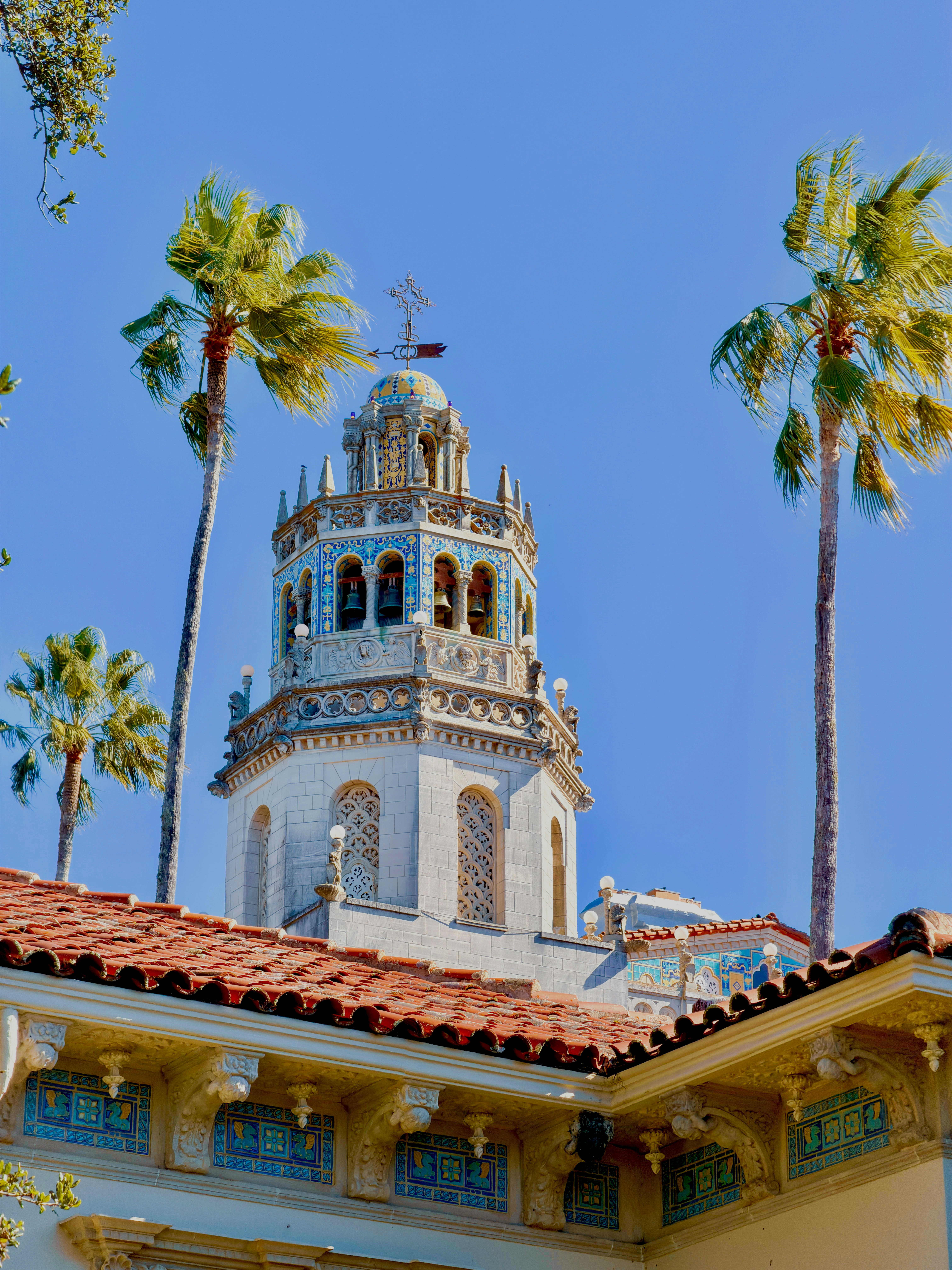 Hearst Castle | Ornate tower with palm trees against blue sky