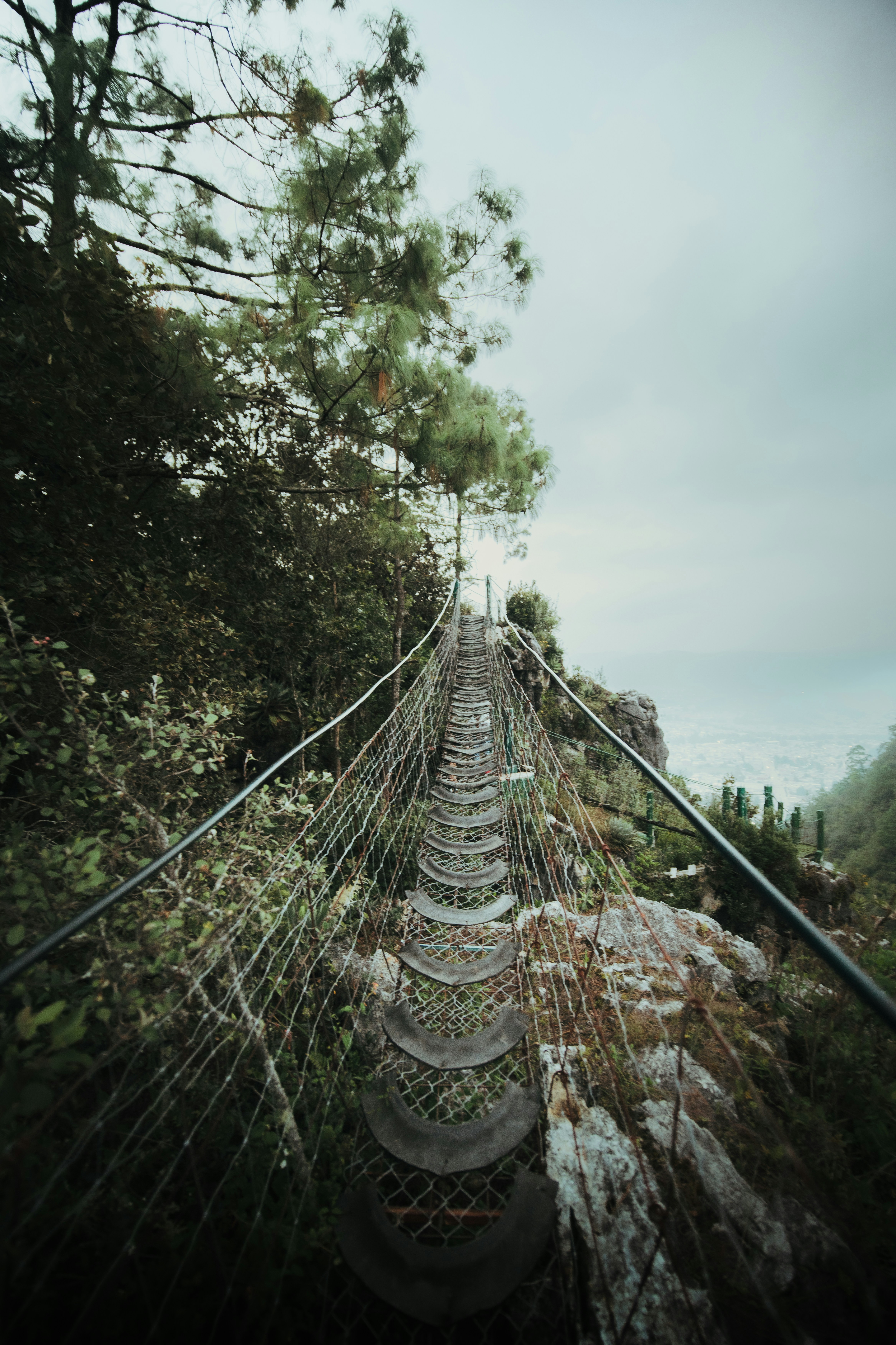 Suspension bridge over a misty mountain landscape