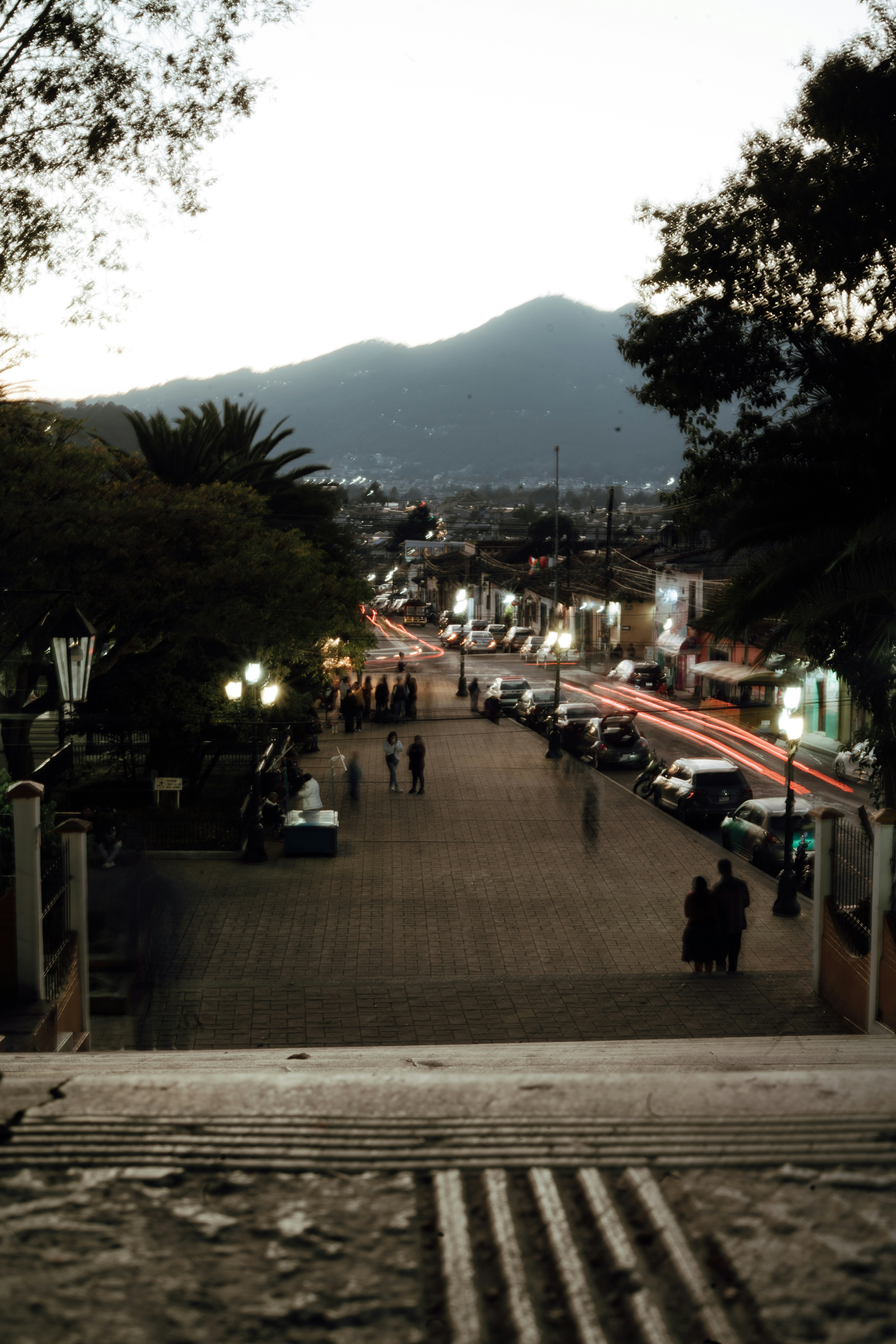 Street scene with cars and people at dusk