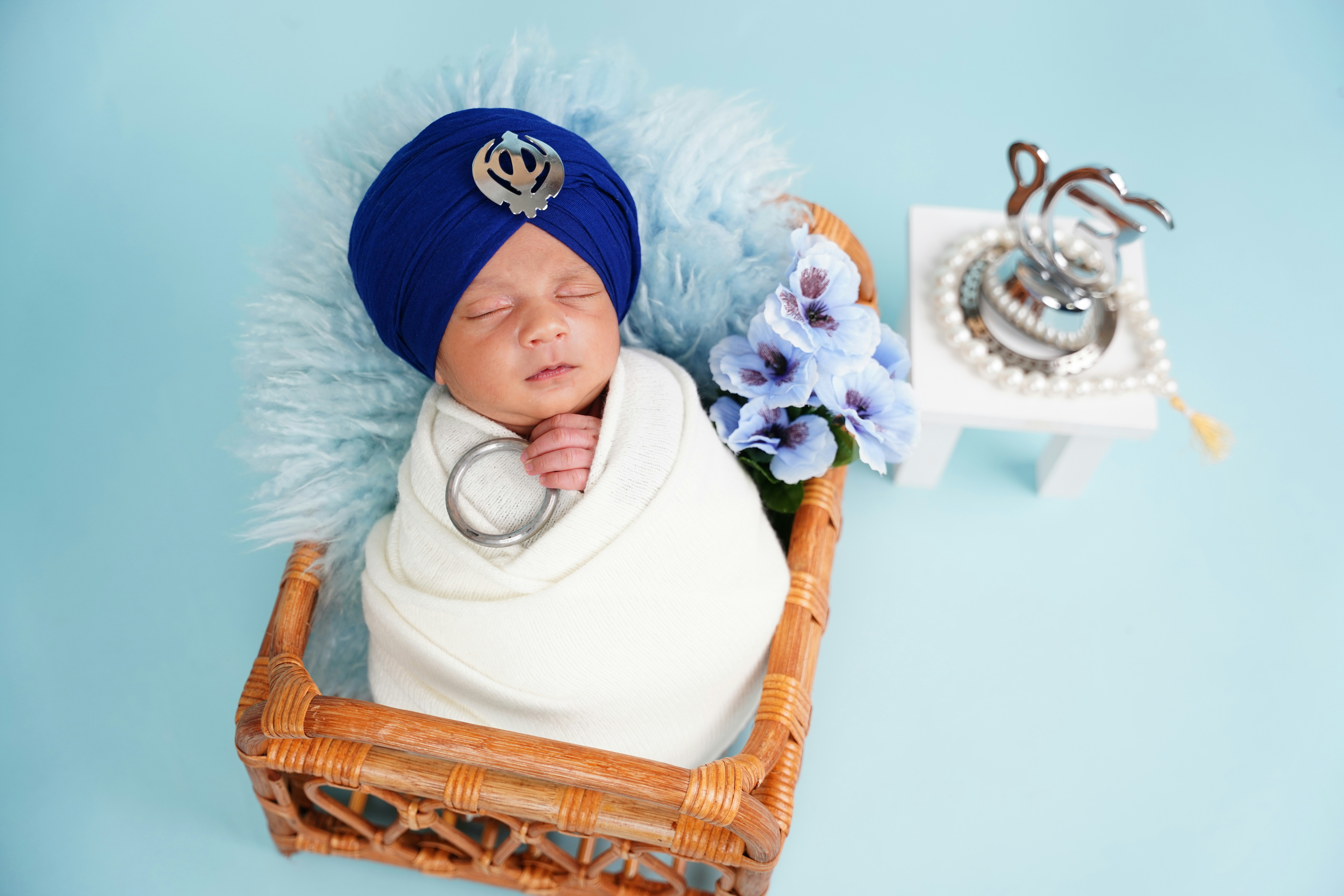 Blue-Turbaned Newborn Resting in a Wicker Nest