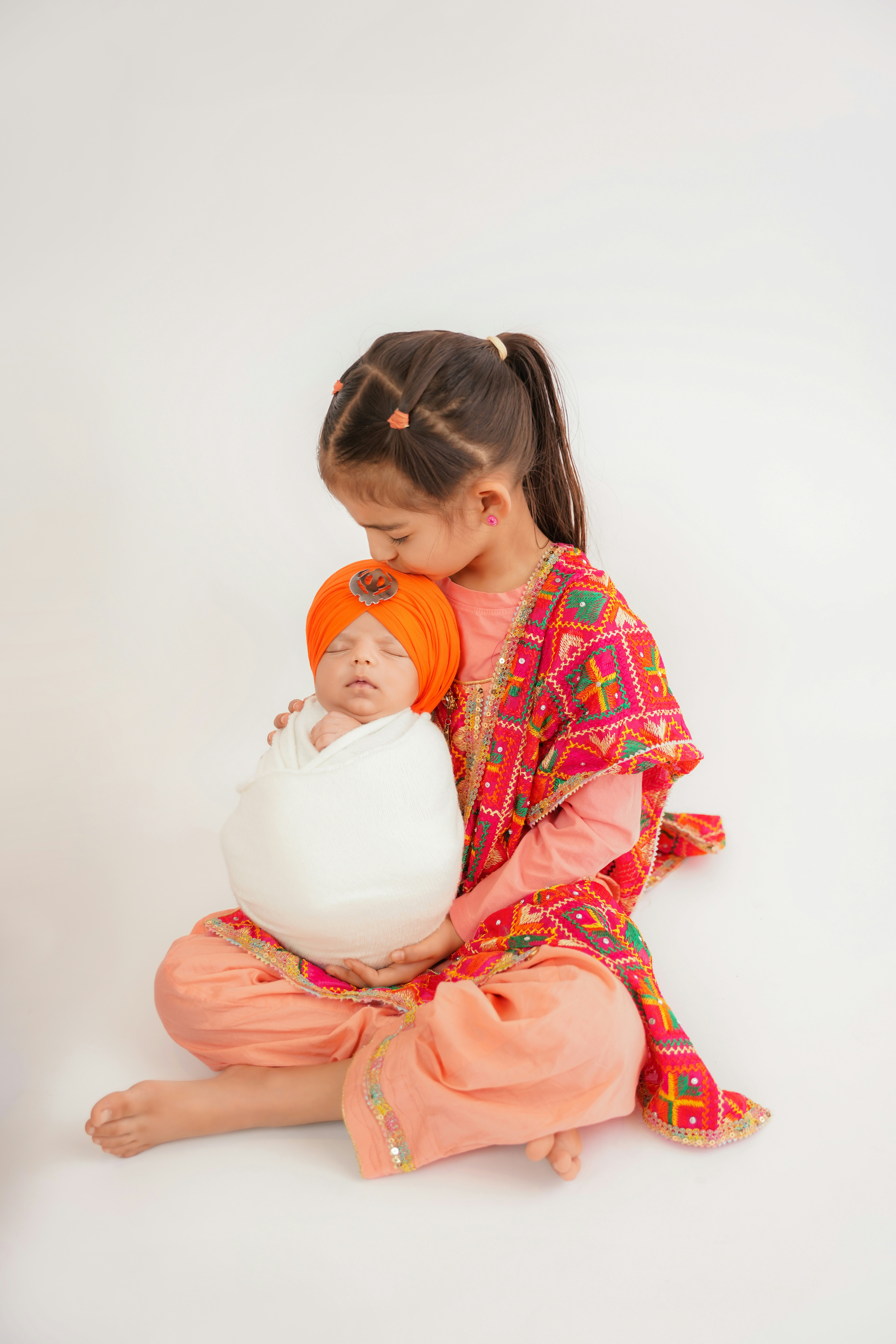 Quiet Radiance: A Sister's Tender Hold in Multicolor Fabric