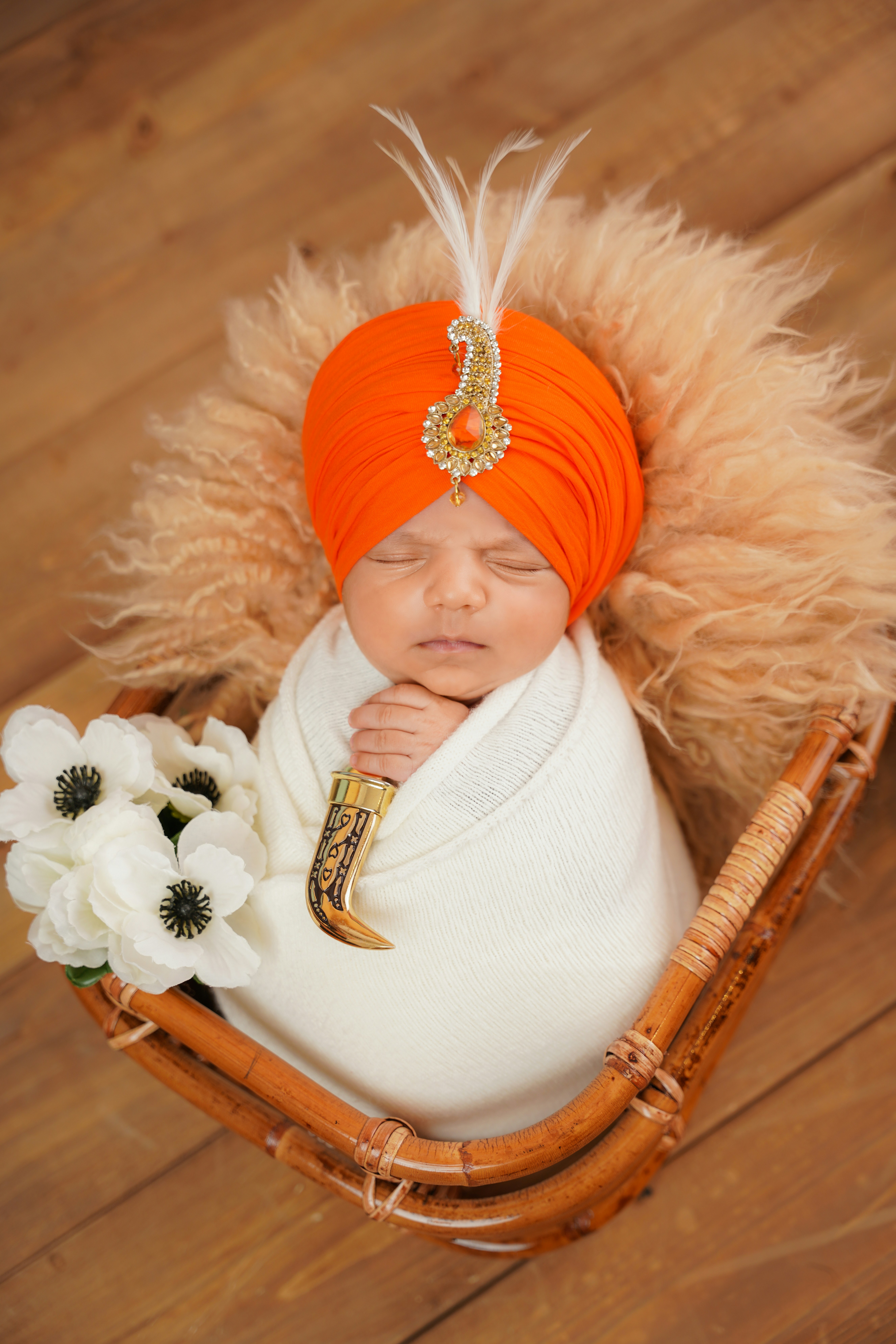 Princely Swaddle: A Sleeping Infant in an Orange Turban with Feathered Jewel