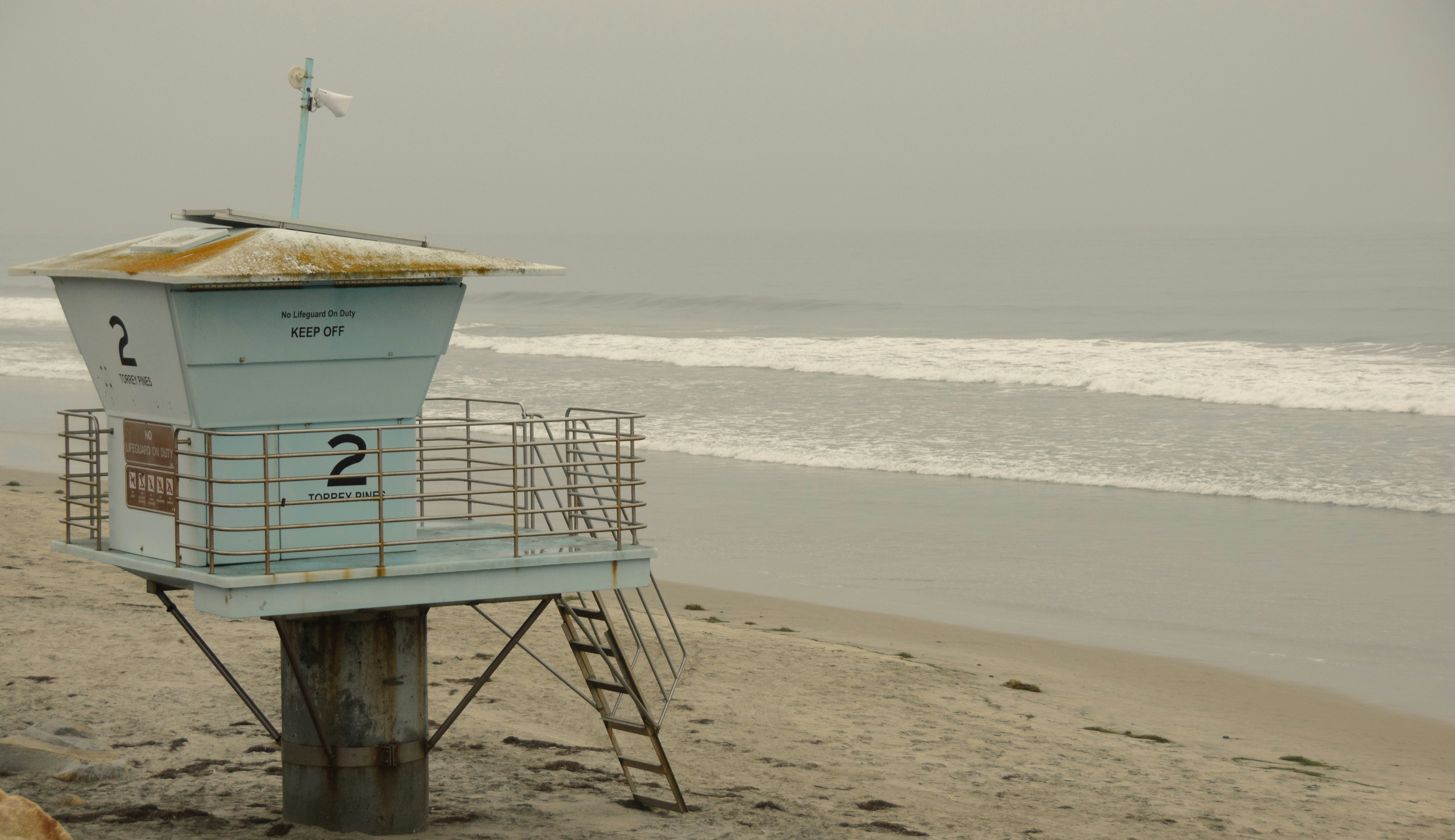 Light blue lifeguard tower on a foggy beach.