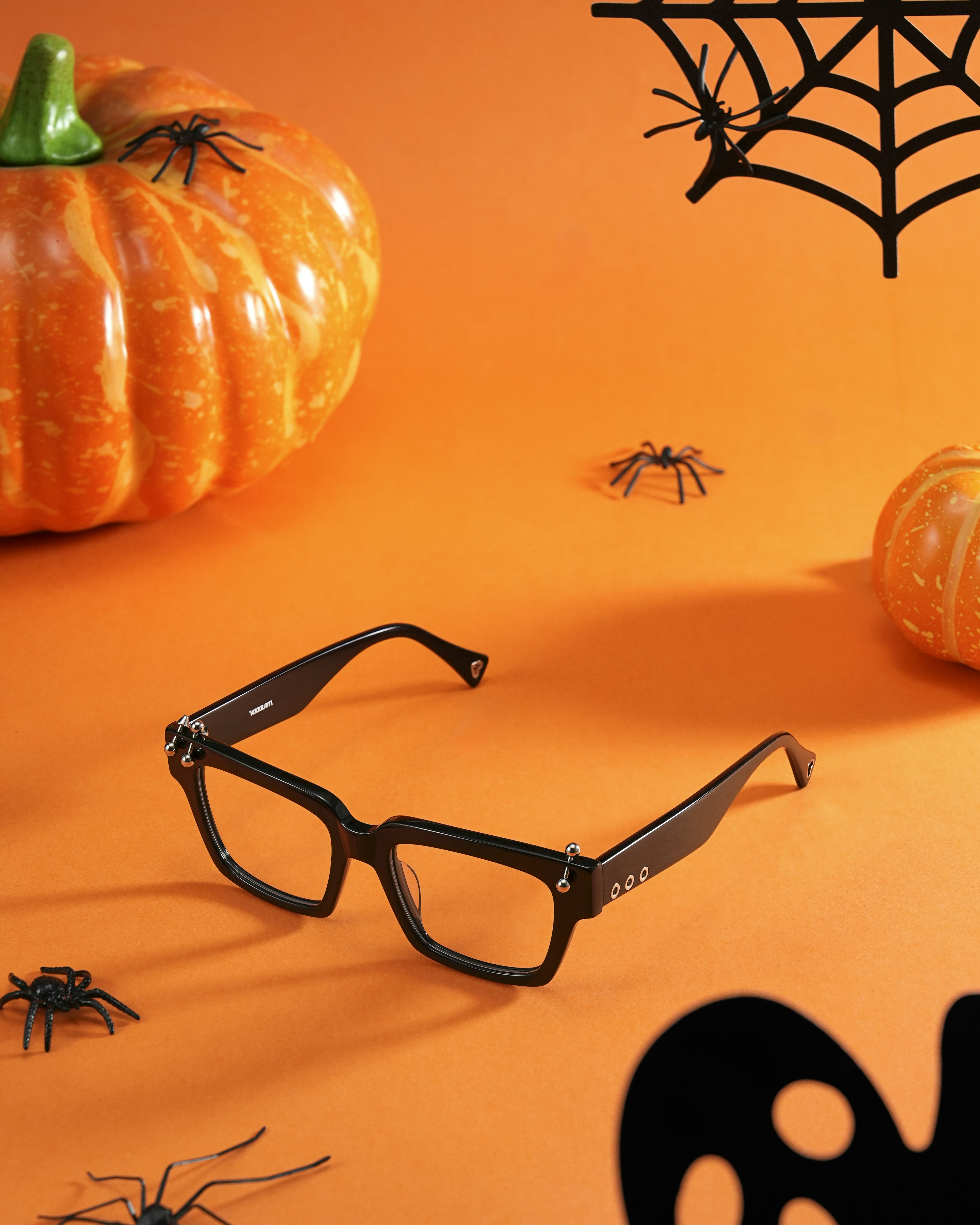 Orange Studio Still Life: Glasses Nestled Among Pumpkins and Spider Webs