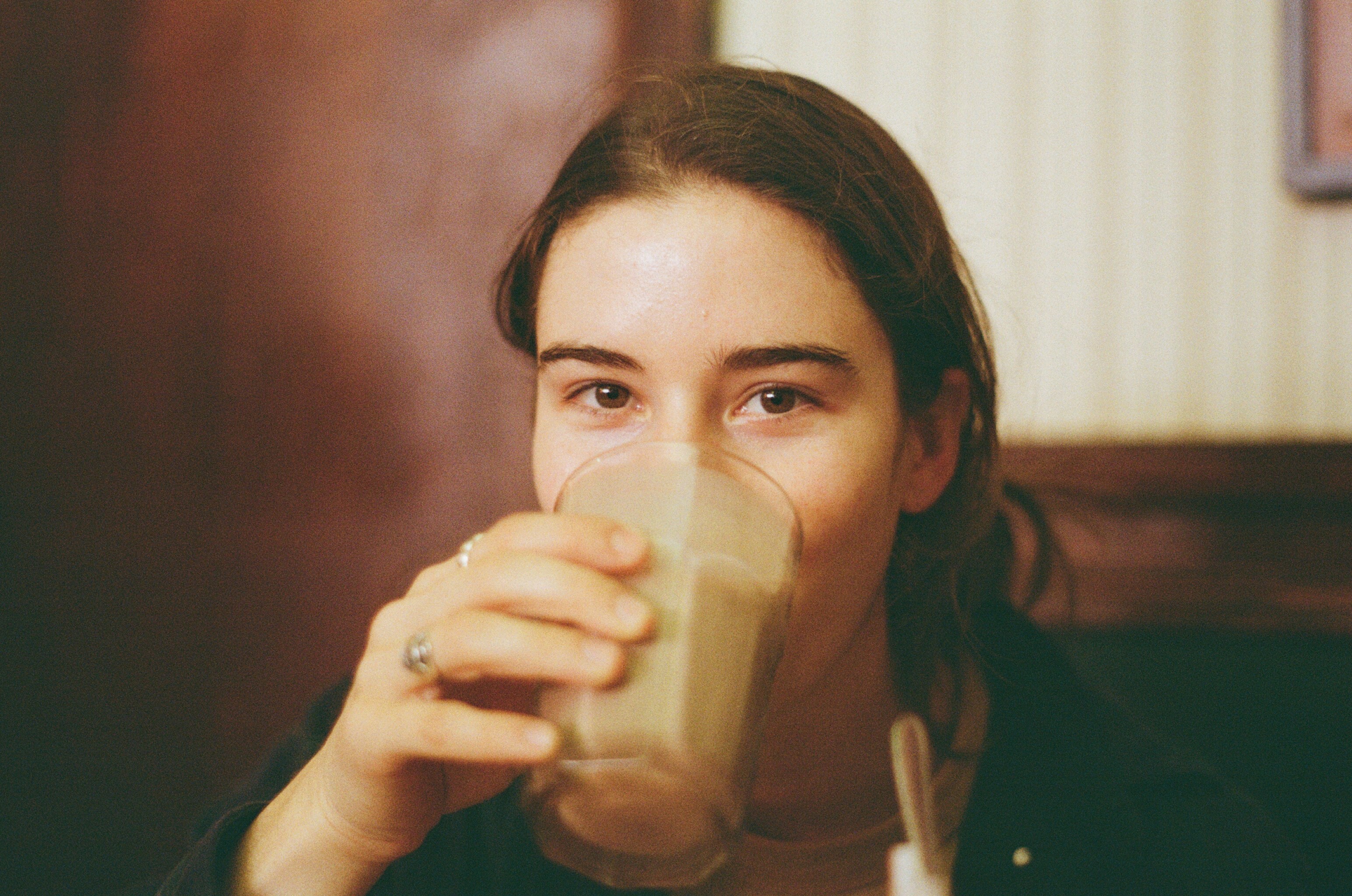Young woman drinking a milkshake at a diner.