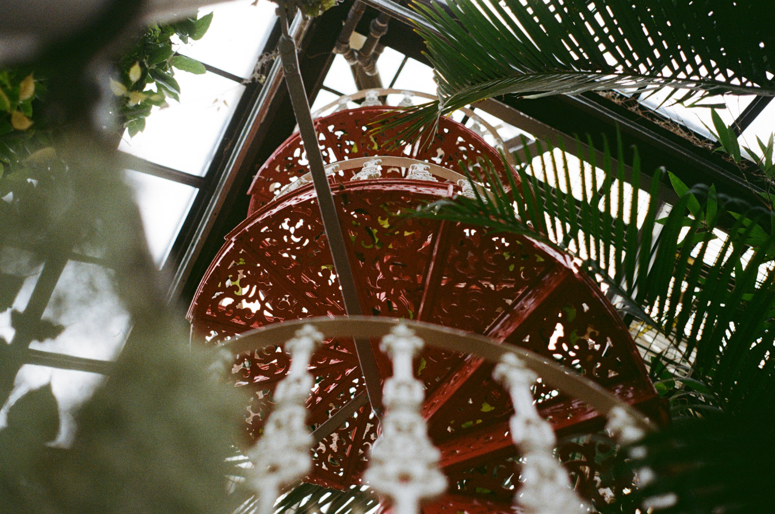 Red spiral staircase with ornate white railing.