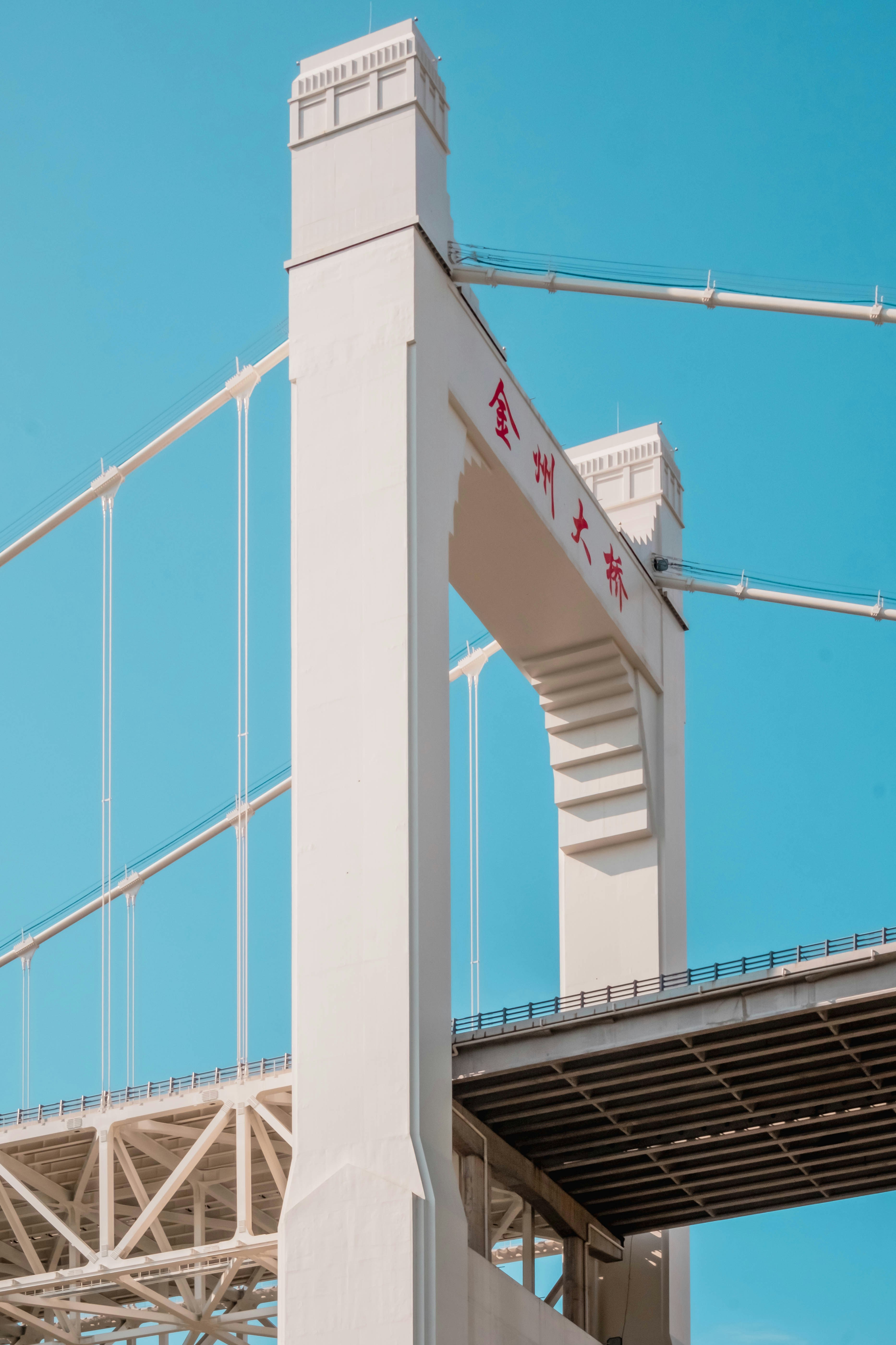 Cerulean Sky Frames a Minimalist White Suspension Tower