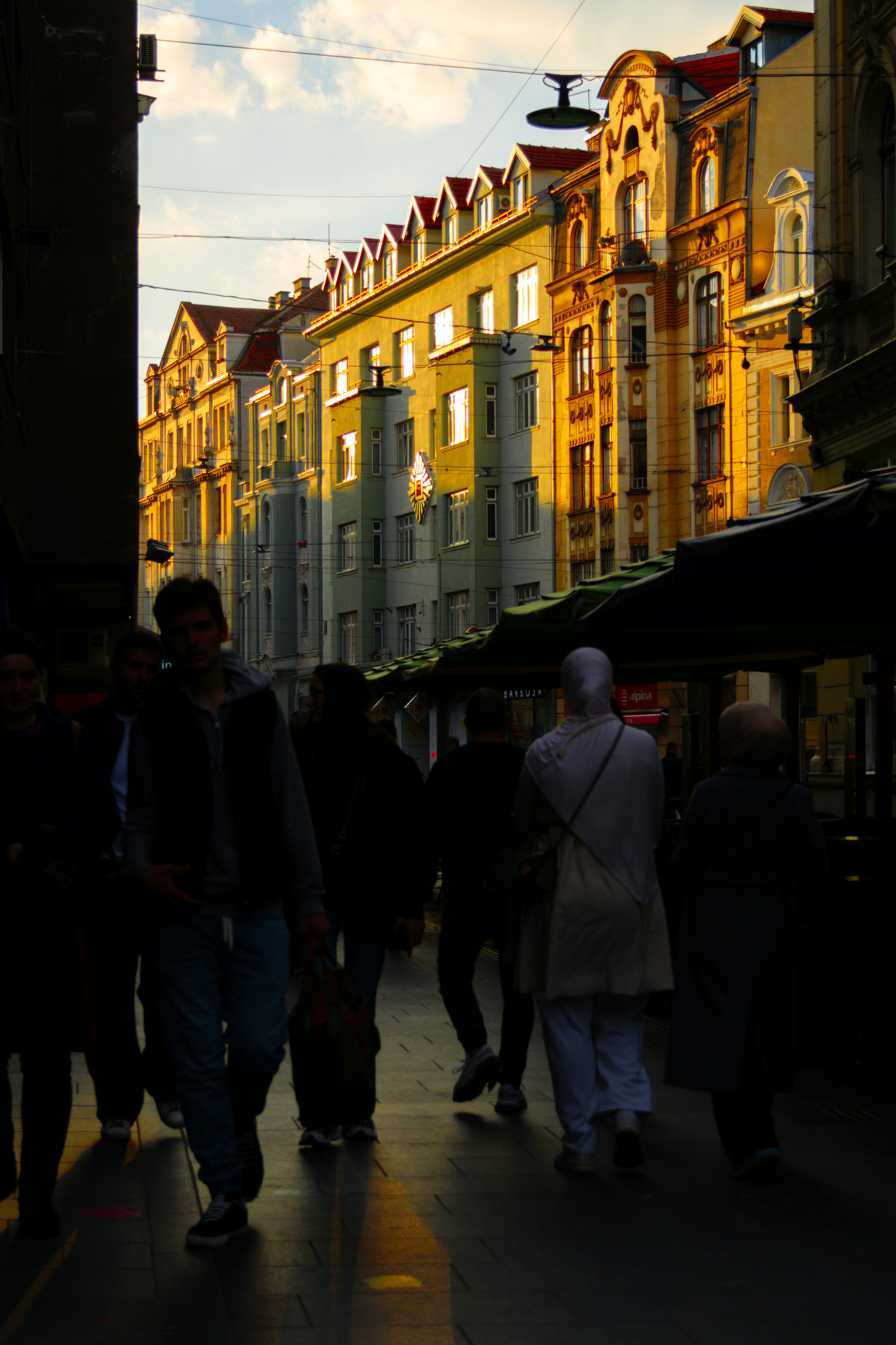 Golden Hour on a Colorful Historic Street with Pedestrian Silhouettes
