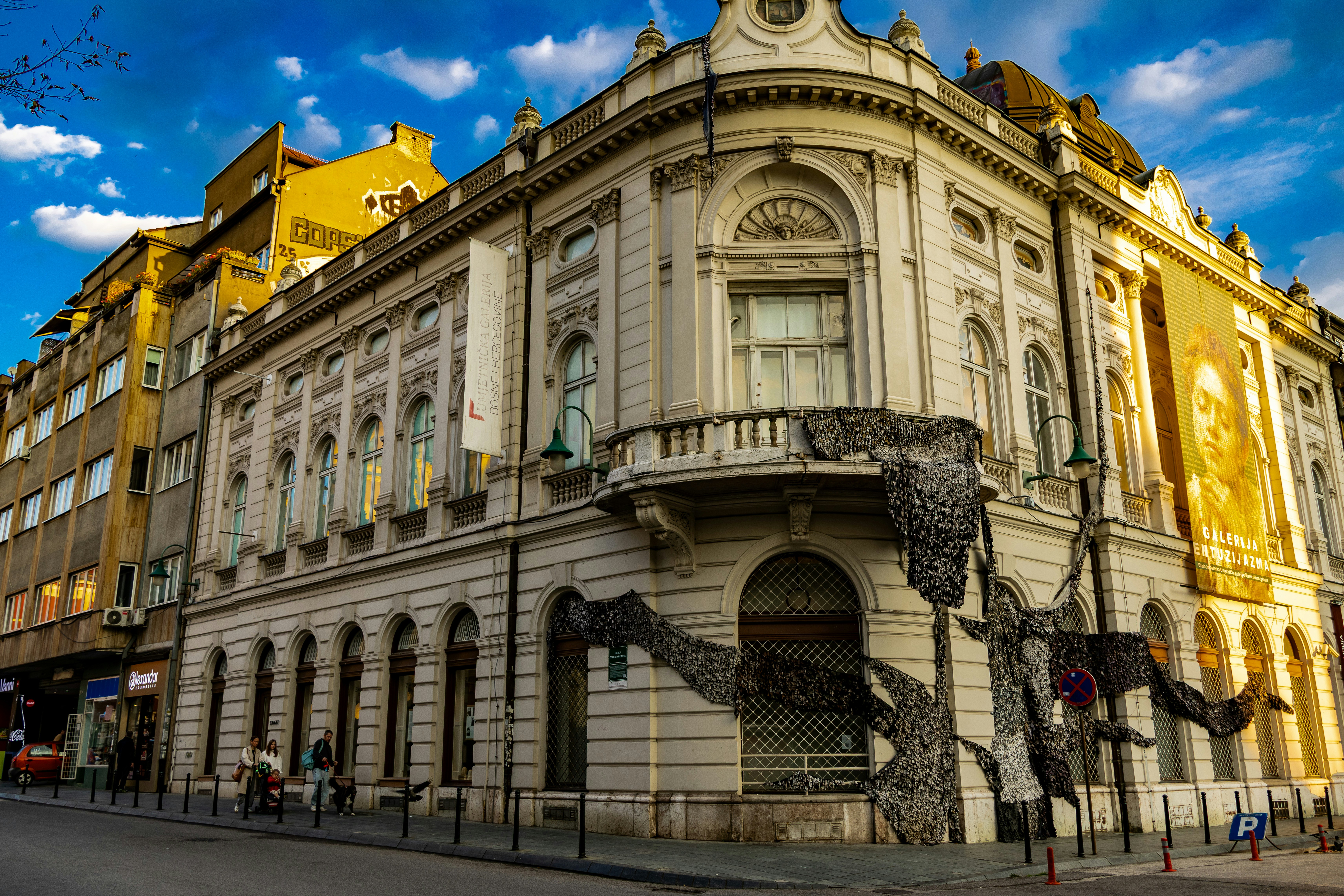 A beautifully adorned historic building featuring a striking mural that blends art with architecture in an urban setting.