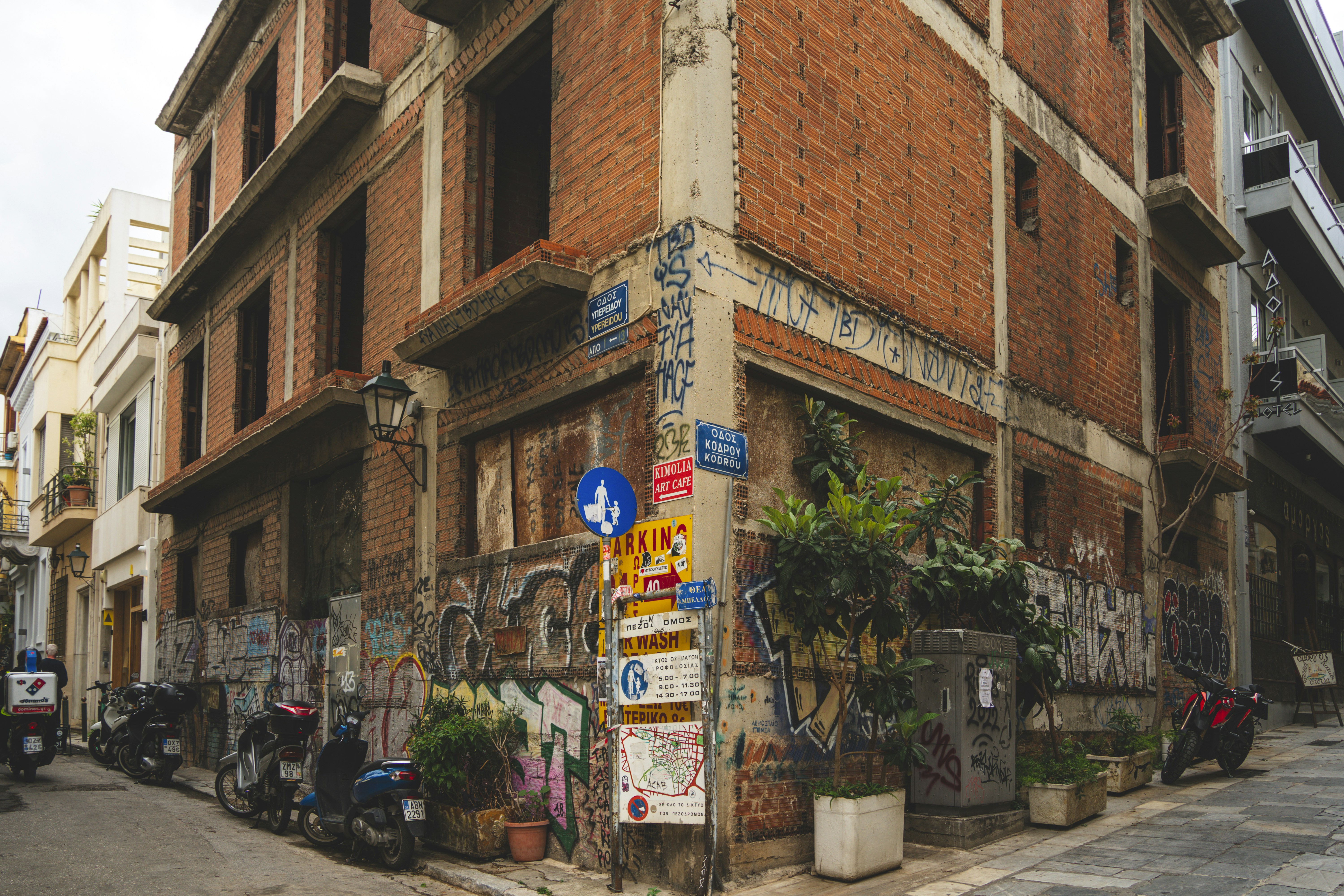 Urban street corner with graffiti and parked motorcycles.