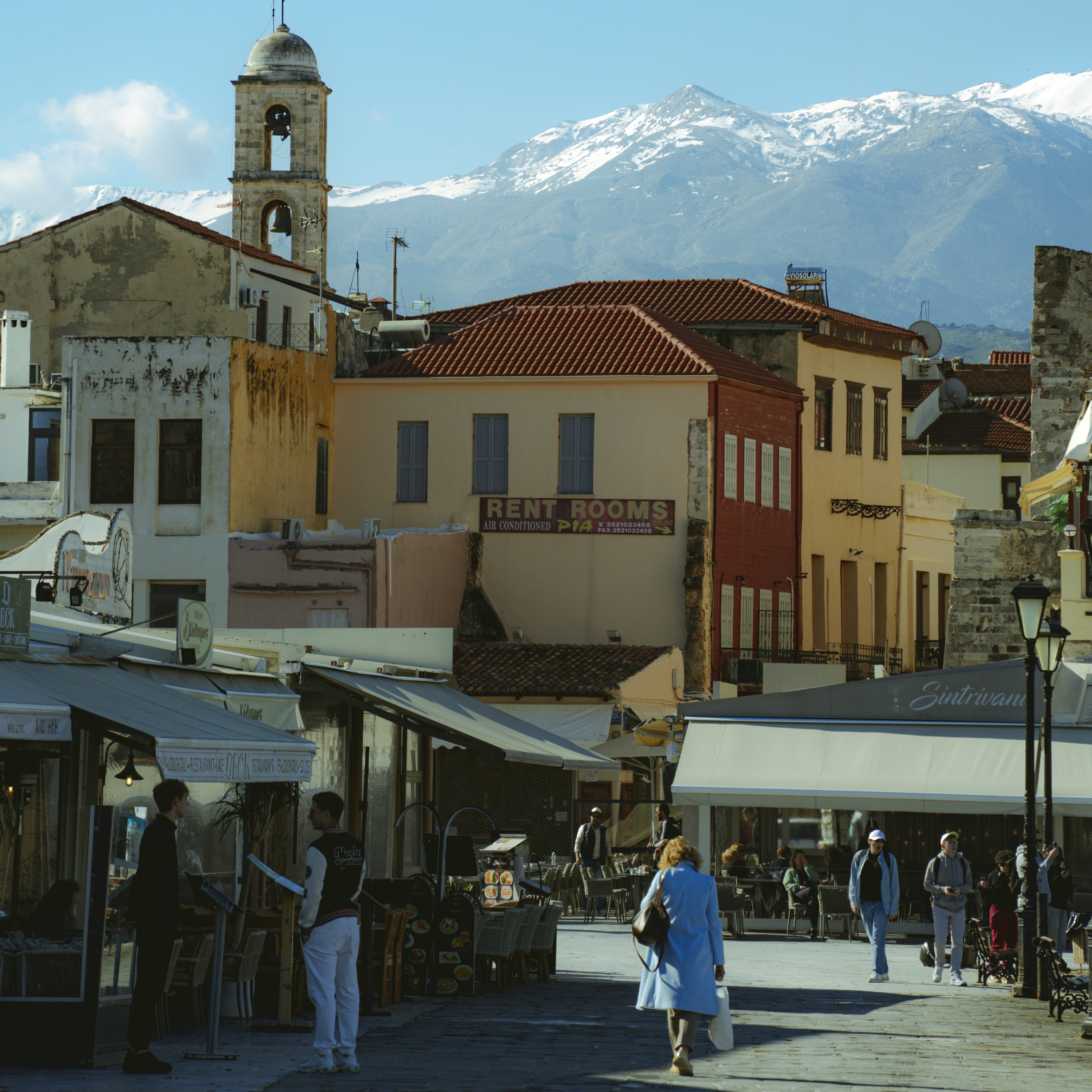 Blue-Clad Moment in a Sunlit Mountain Town Plaza