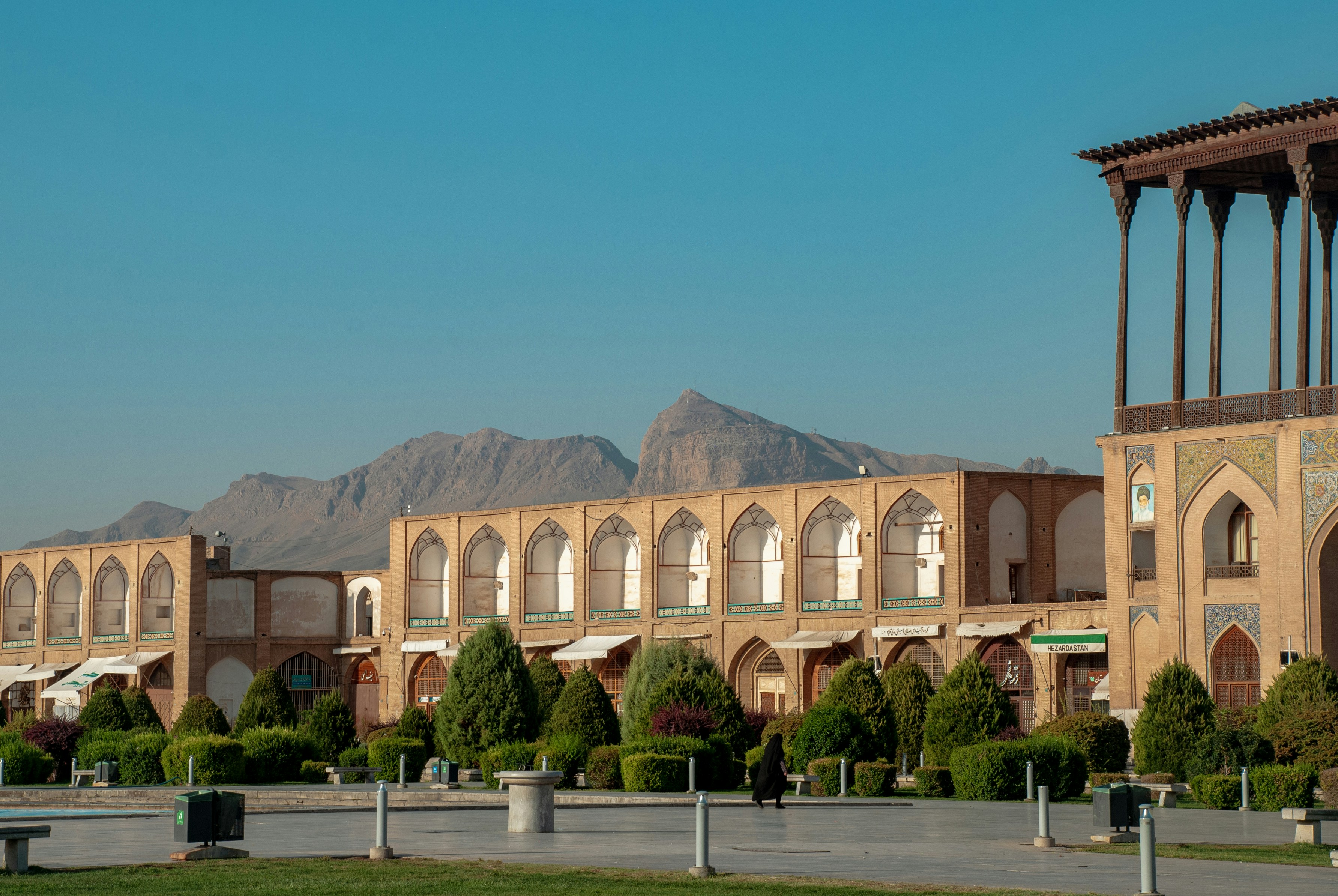 Through the viewfinder of an old Nikon, I saw a city that never lost its rhythm. | Historic buildings with arched windows and mountains beyond