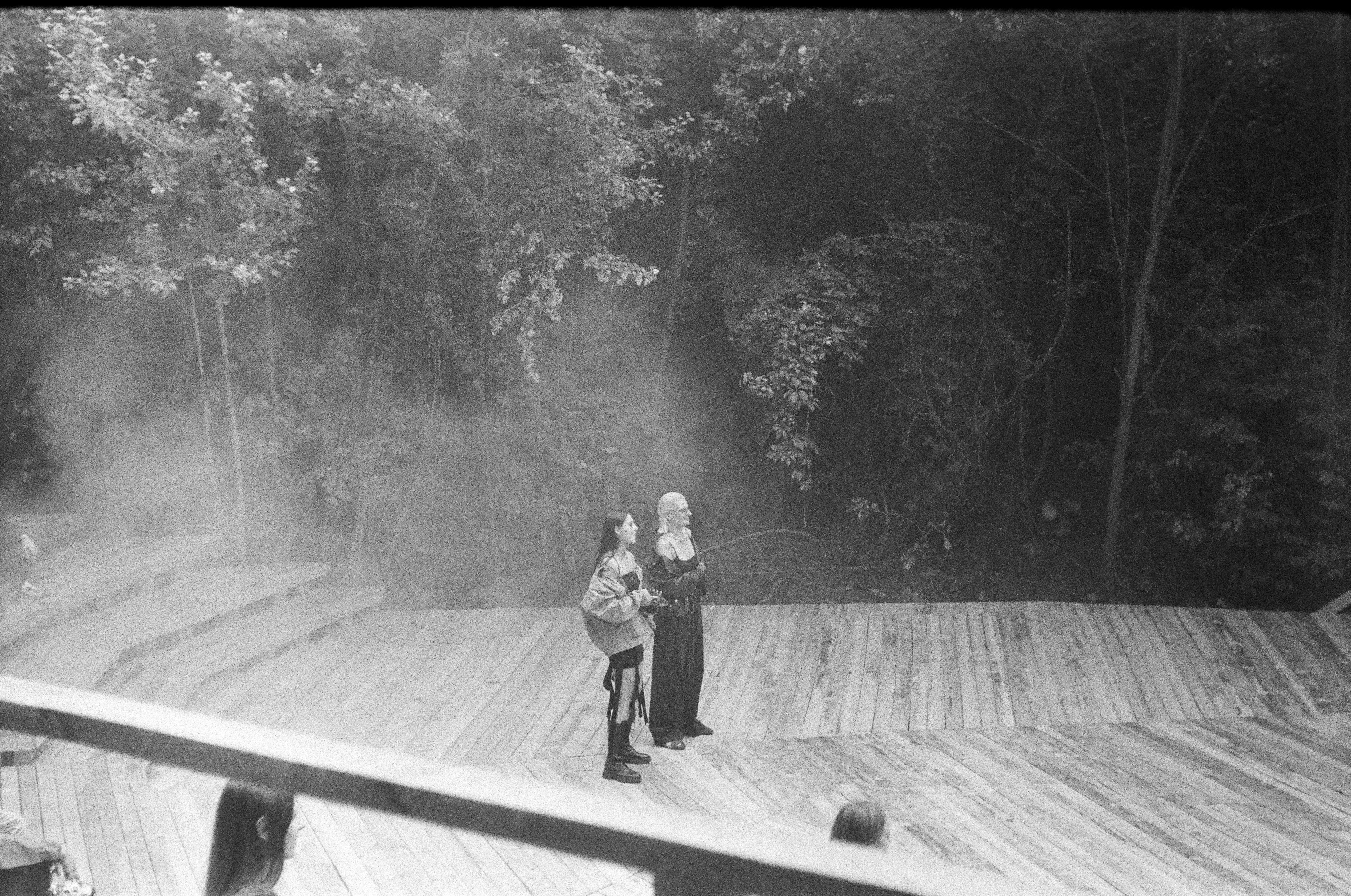 Two people stand on a wooden stage outdoors. photo – Free Forest Image ...