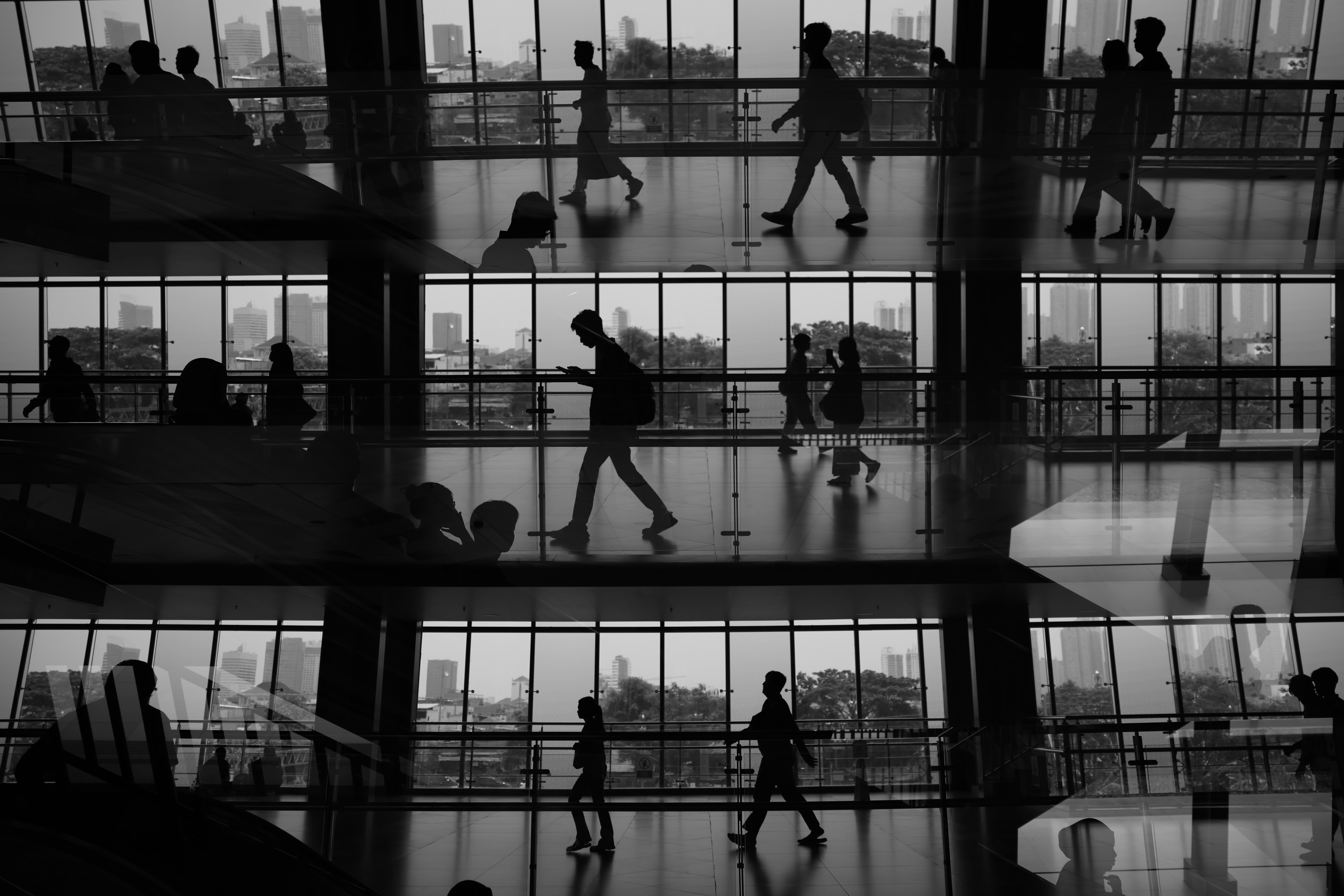 Silhouettes of people walking in a modern building