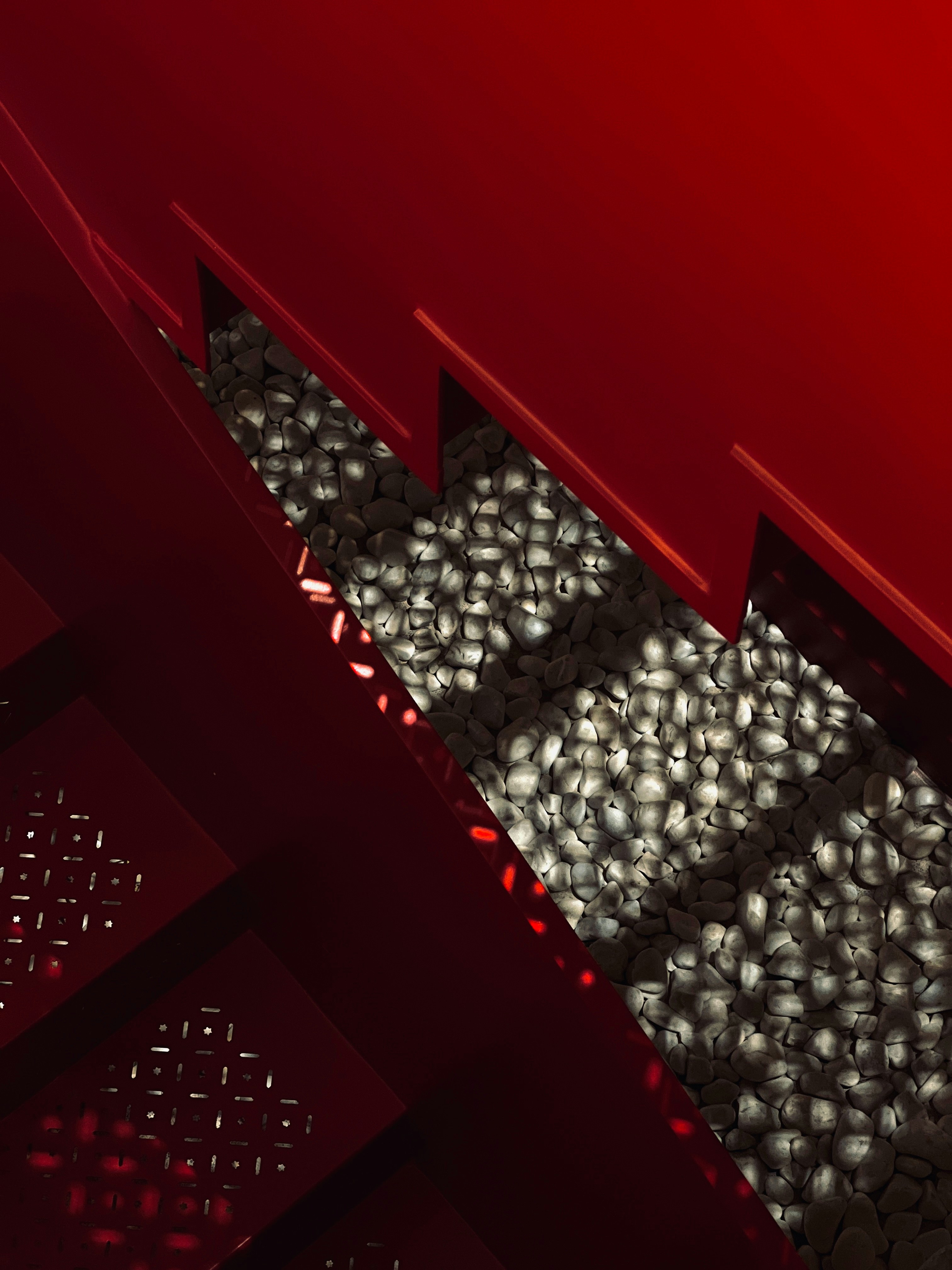 Crimson Angles Over a Pebble-Lit Corridor
