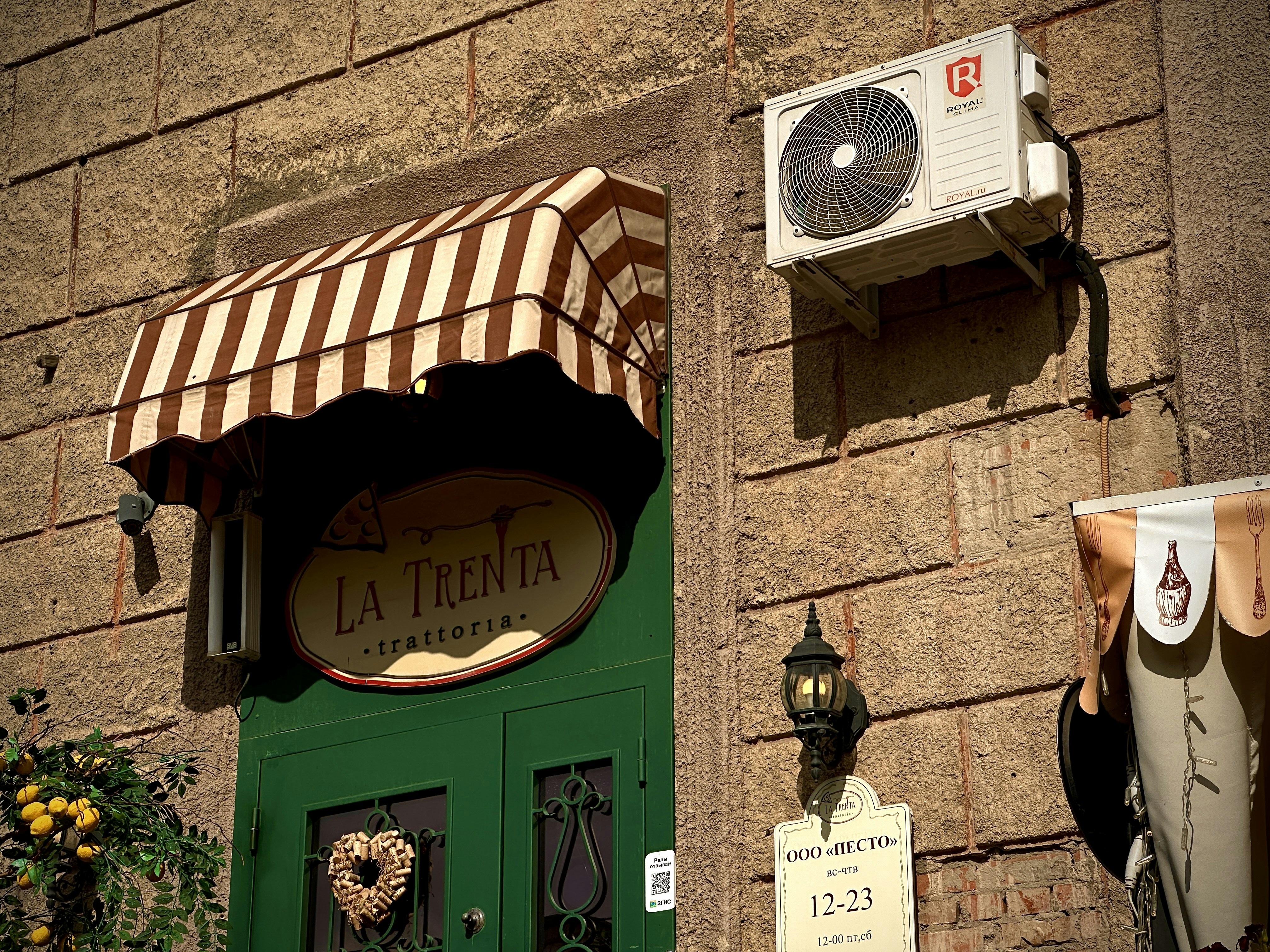 Restaurant awning over a green door with sign.
