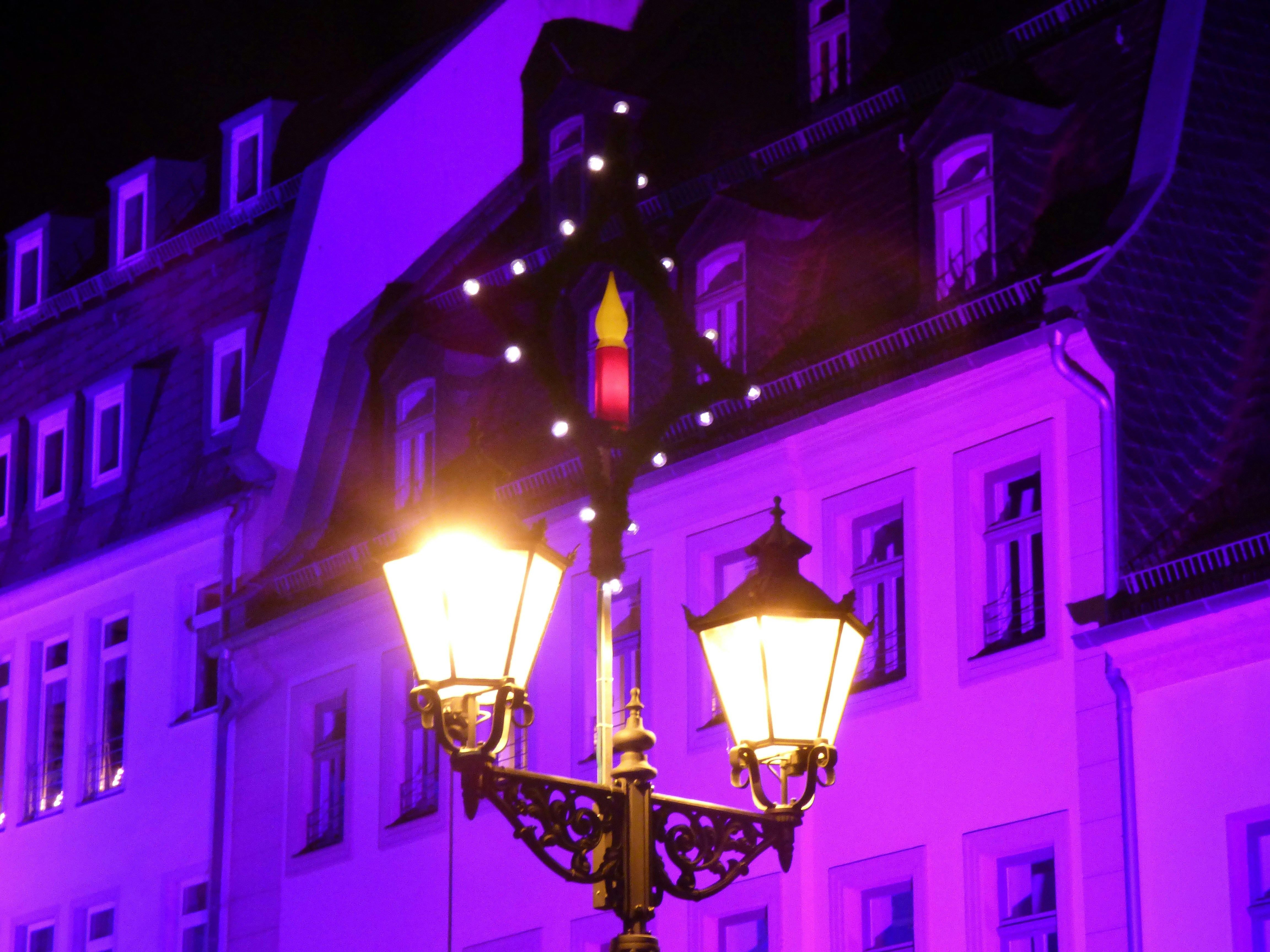 Street lamp with candle and purple building lights