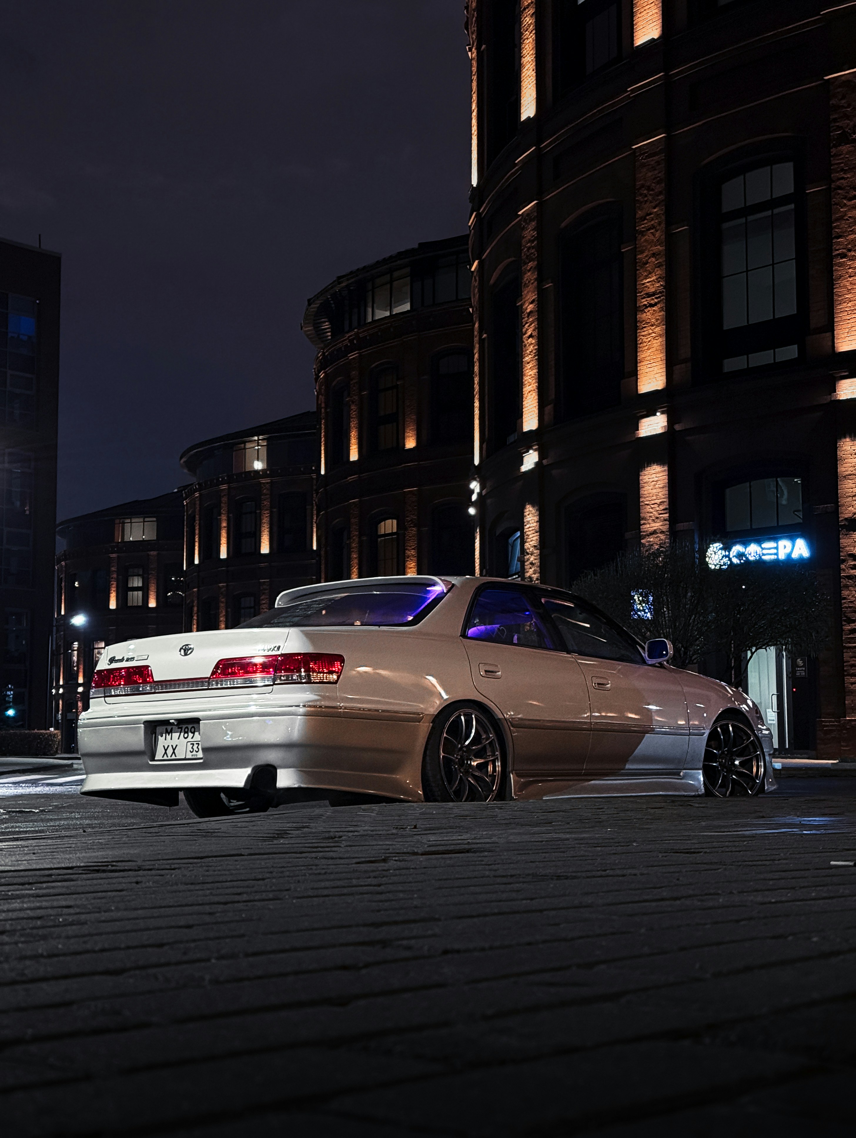 Rear-Quarter Quiet: A White Coupe Bathed in Urban Nightlight