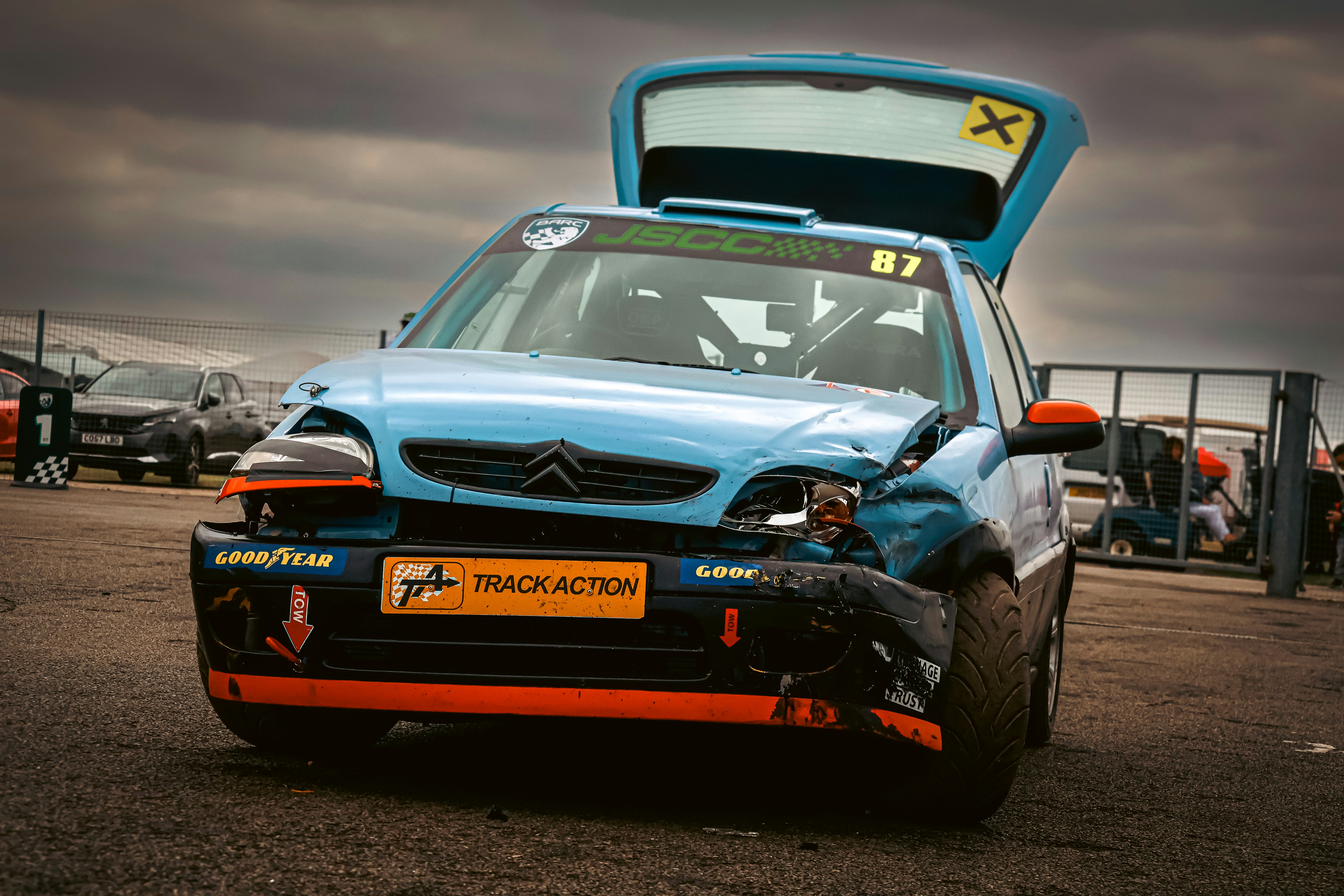 Blue Citroën Rally Car: Front-End Battle Scars Beneath a Stormy Track Sky