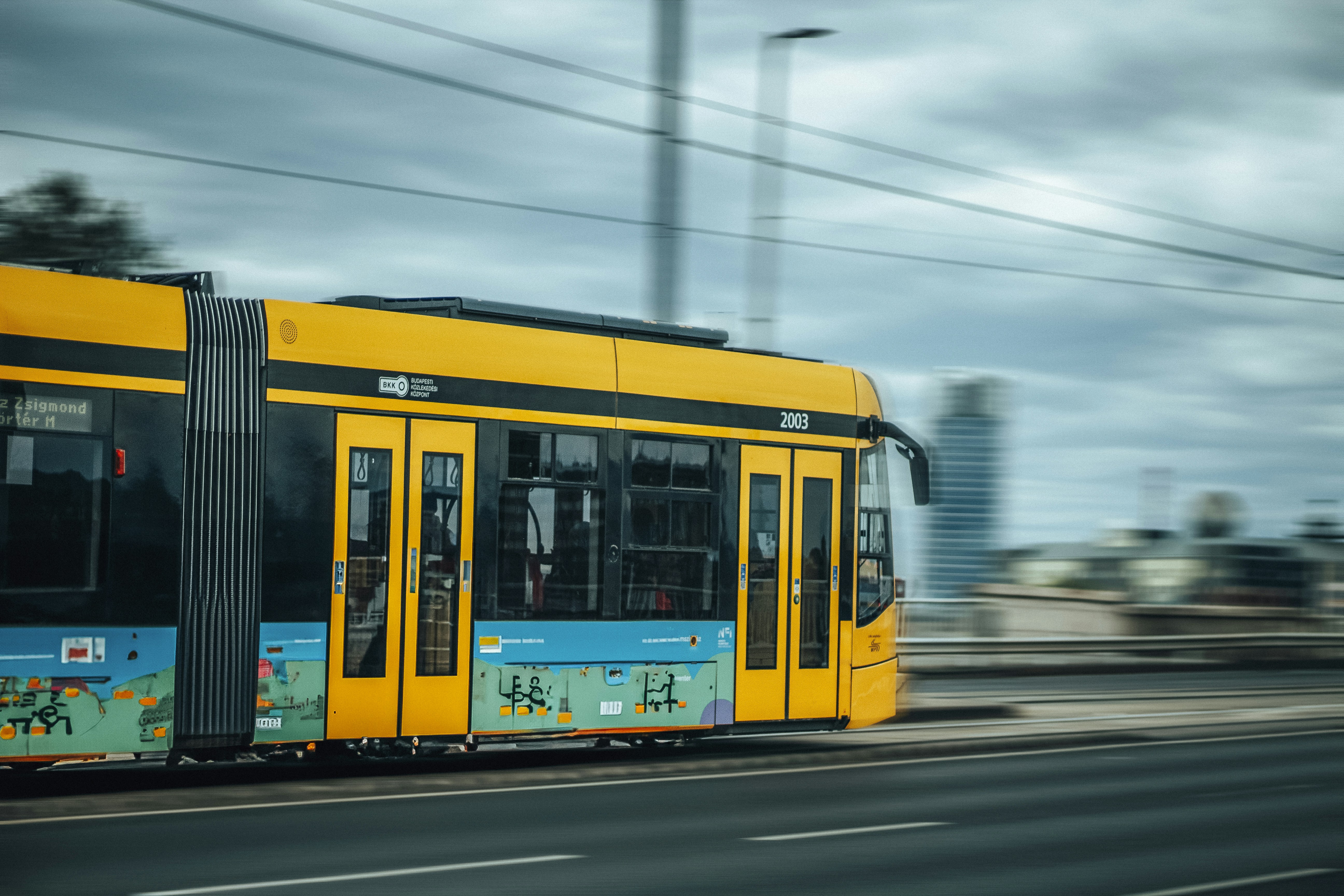 A yellow tram moving fast on a cloudy day. photo – Free City Image on ...