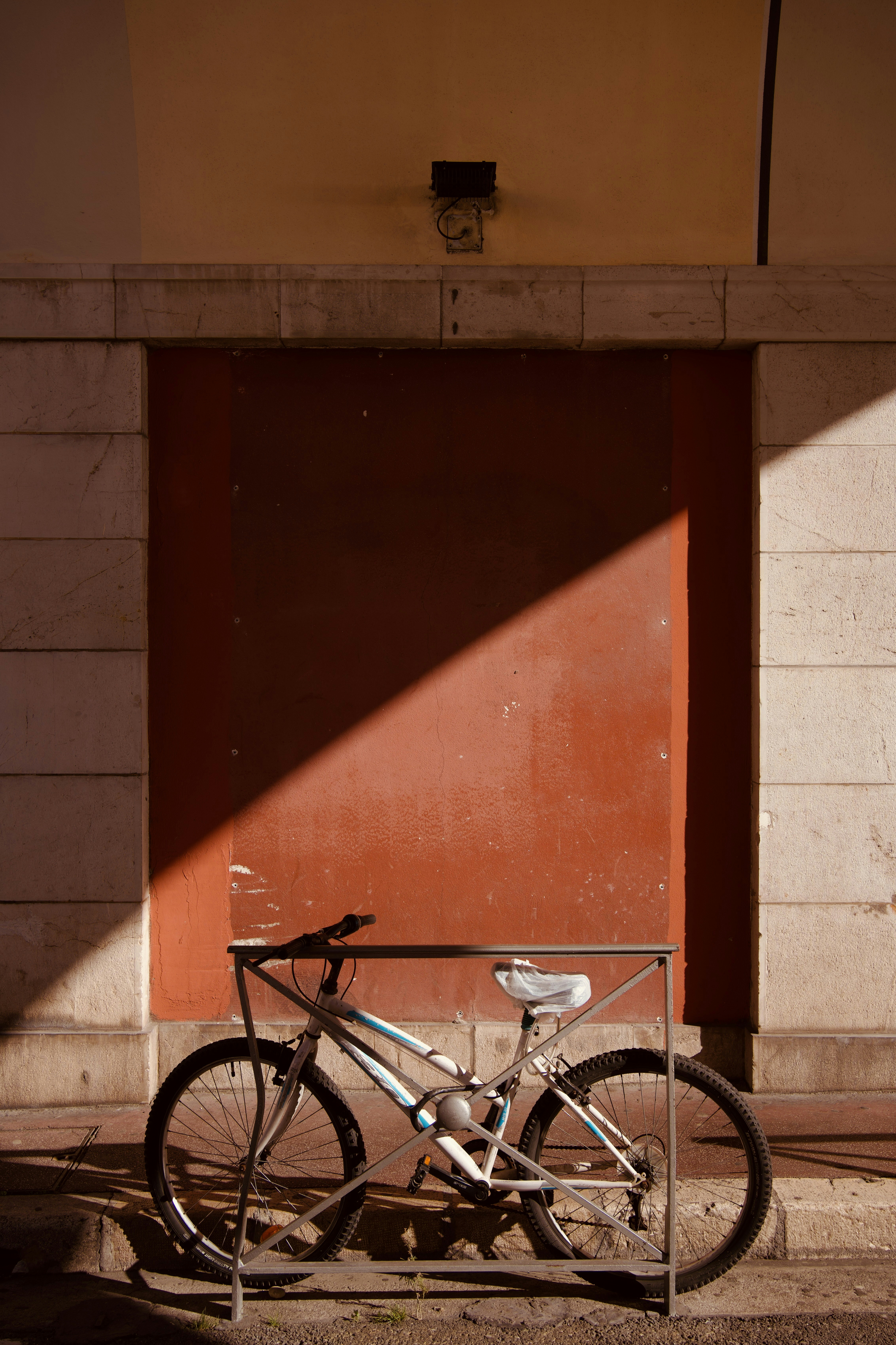 A bicycle parked against a red wall