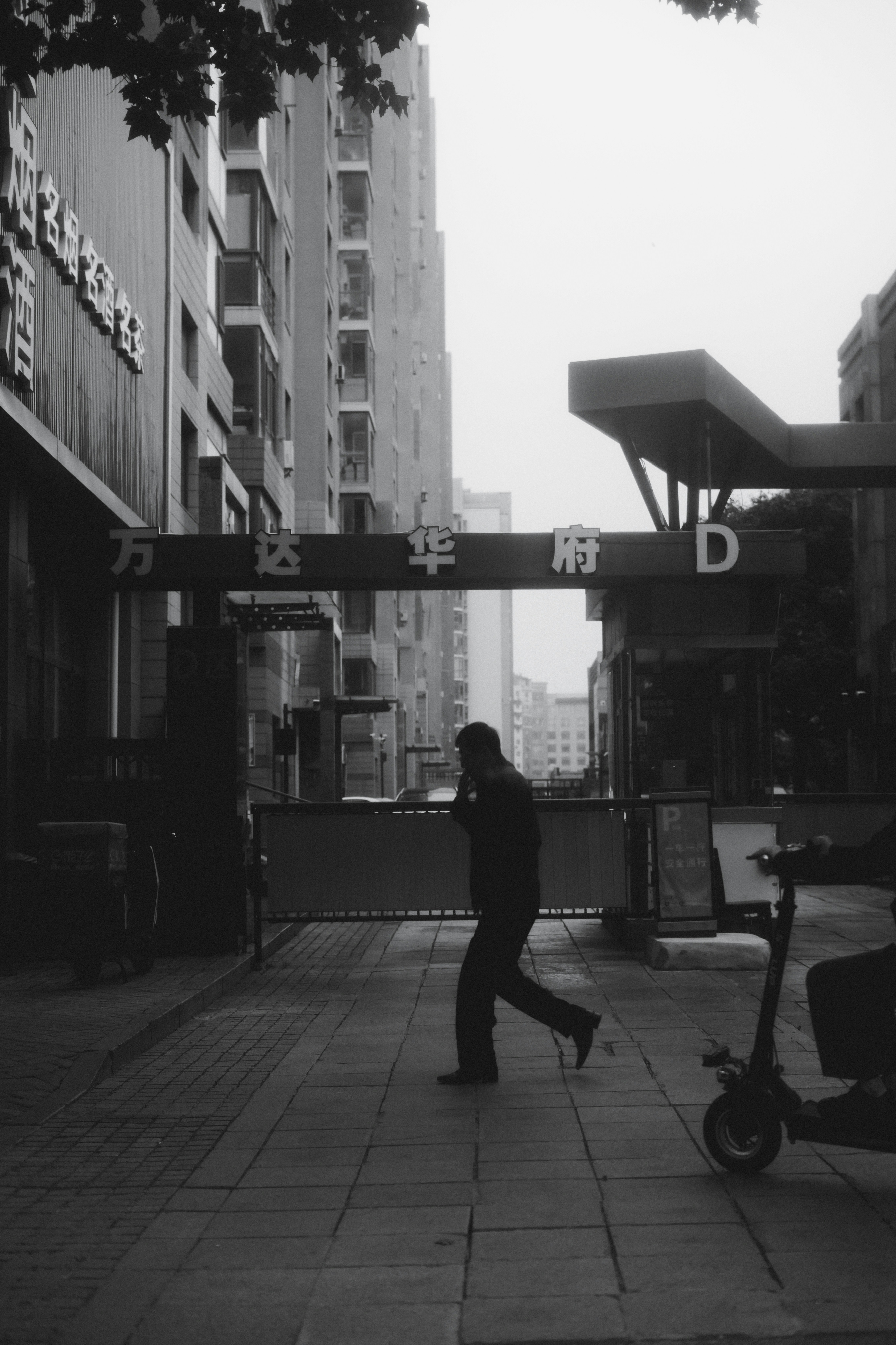 Man walks down a city street with buildings.