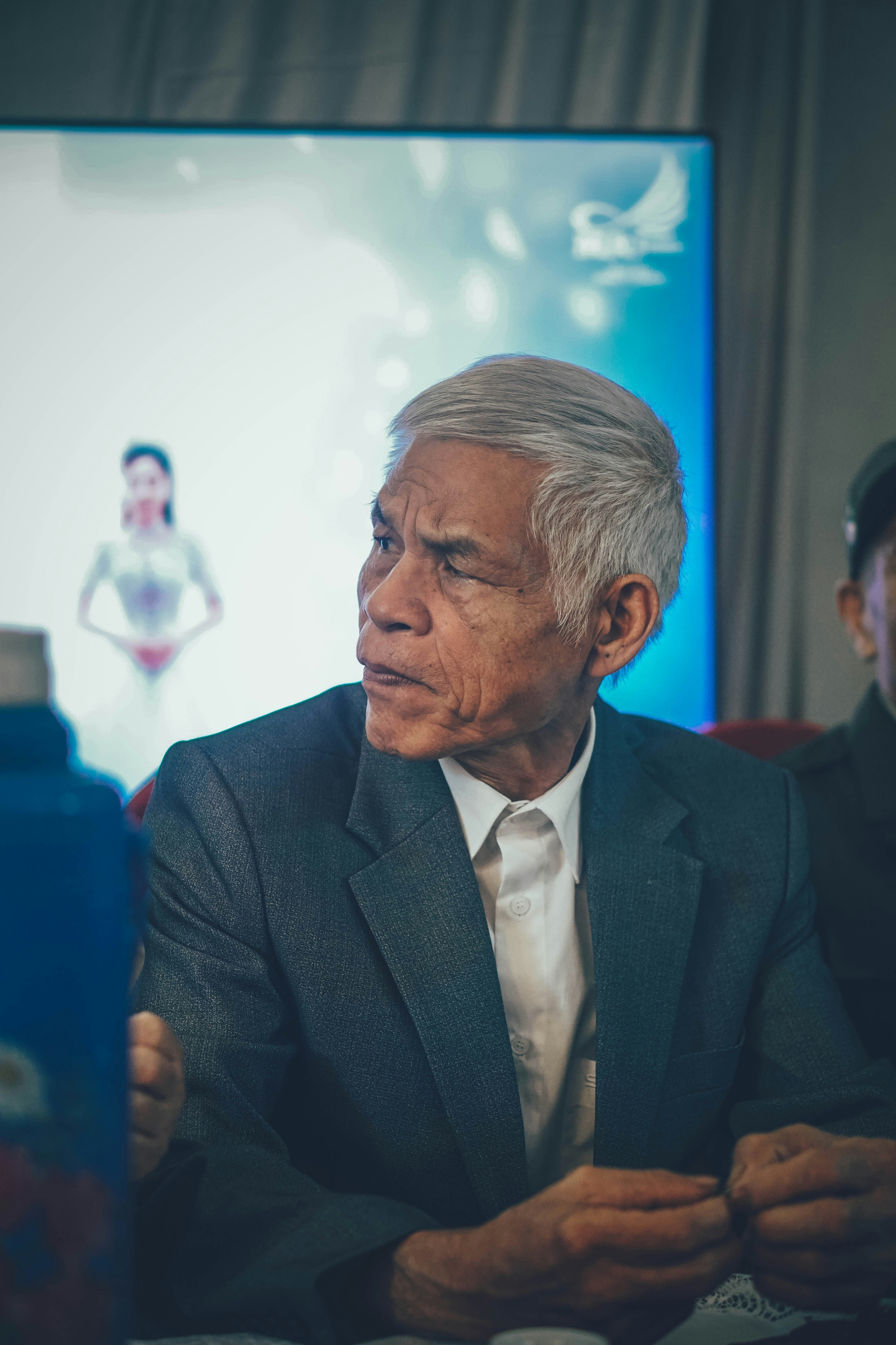 Elderly man in a suit looking to the side.