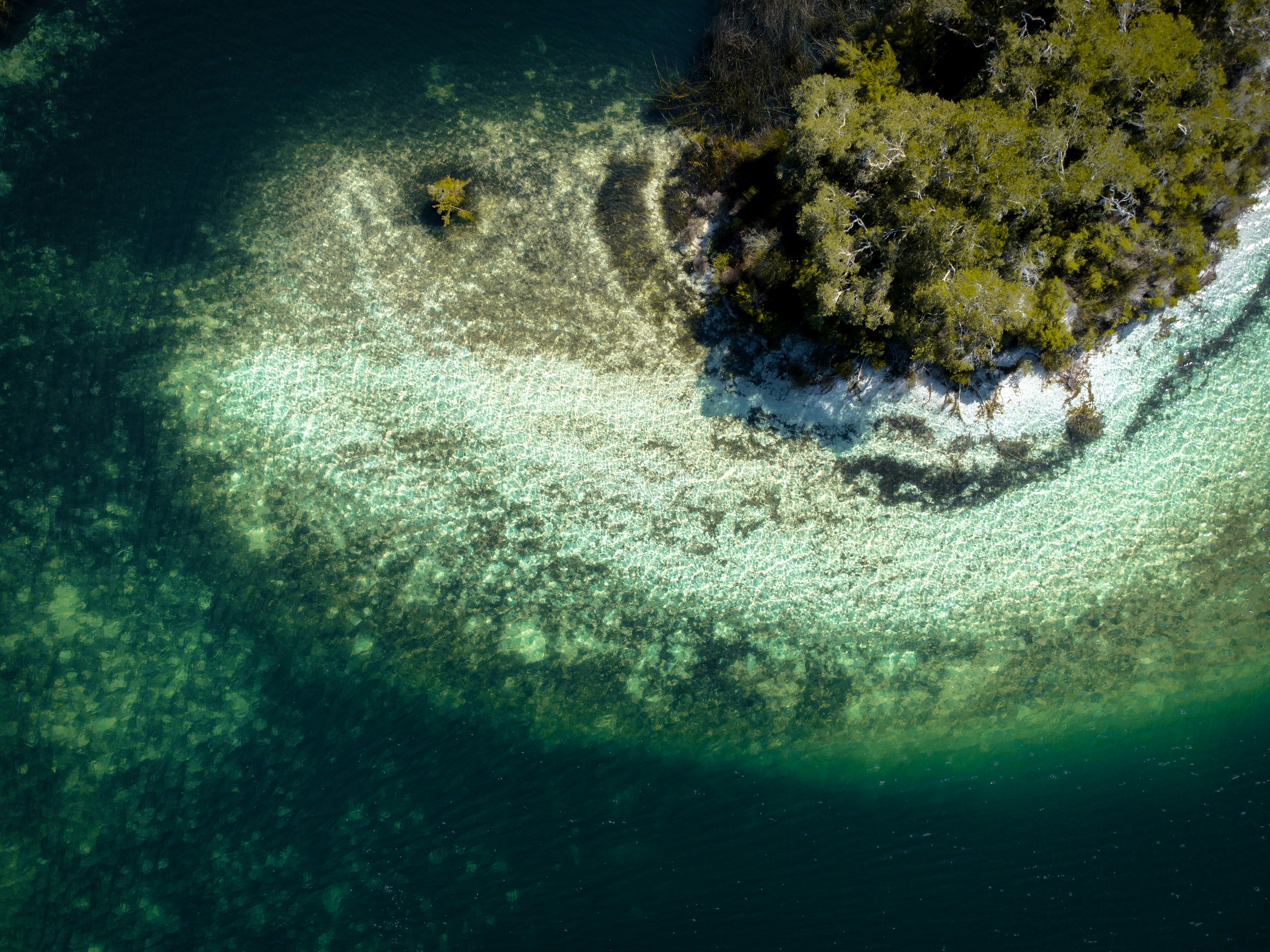 Aerial view of a small island with clear turquoise water.