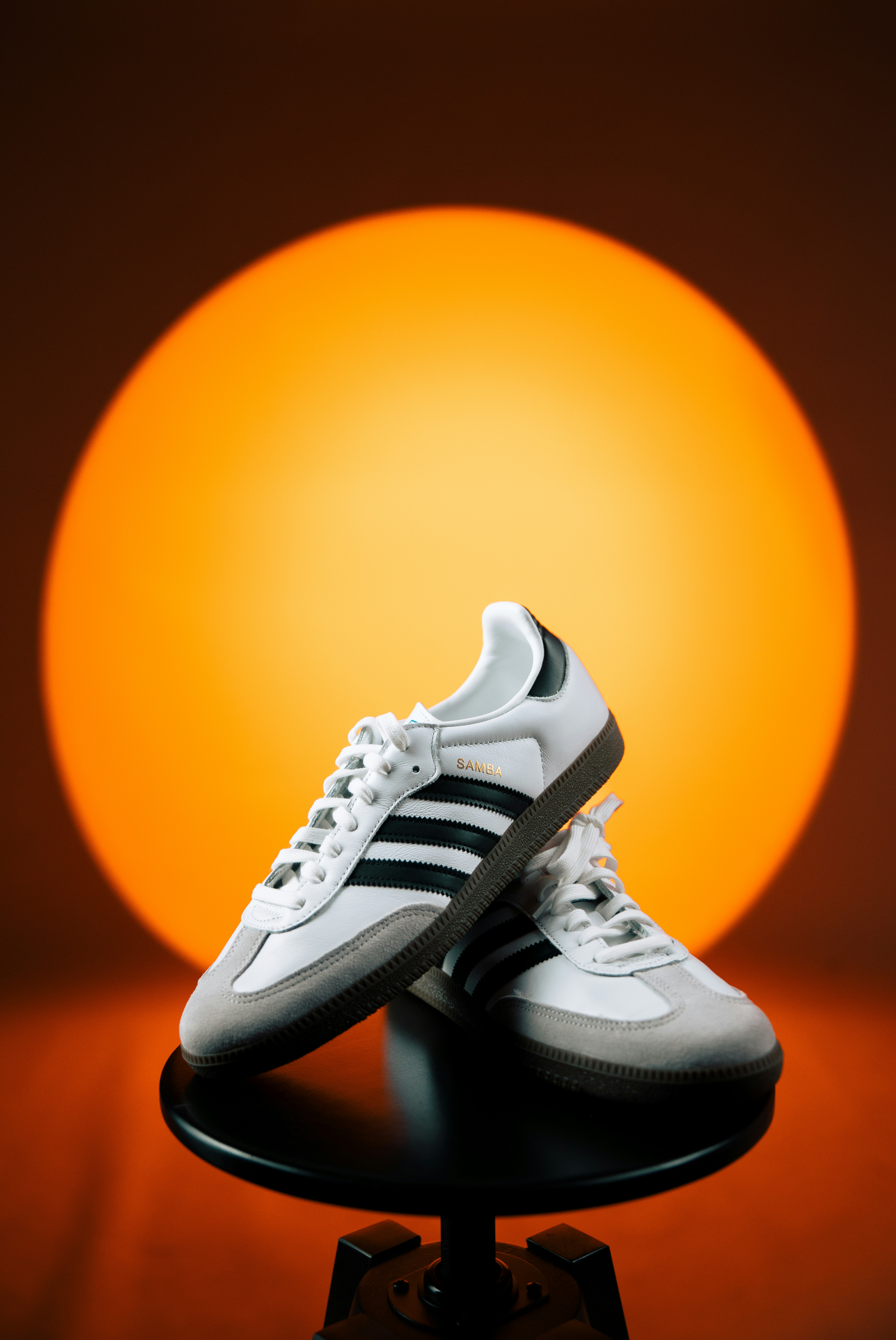 Orange Halo Over White Sneakers: A Studio Still on a Pedestal